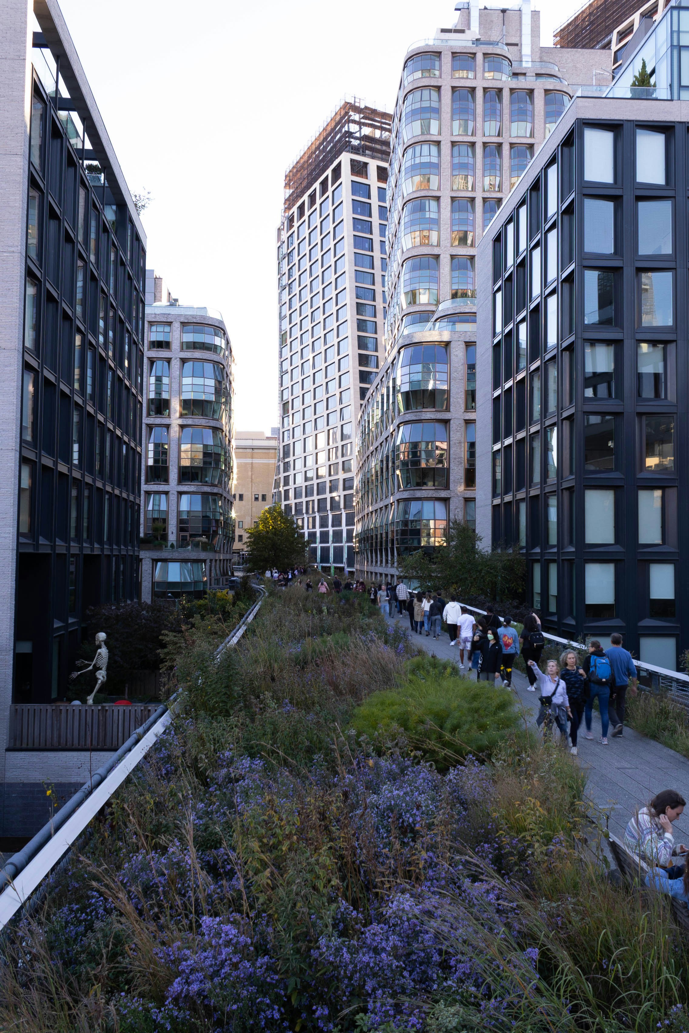 A group of people walking on a path between buildings photo – Free High ...