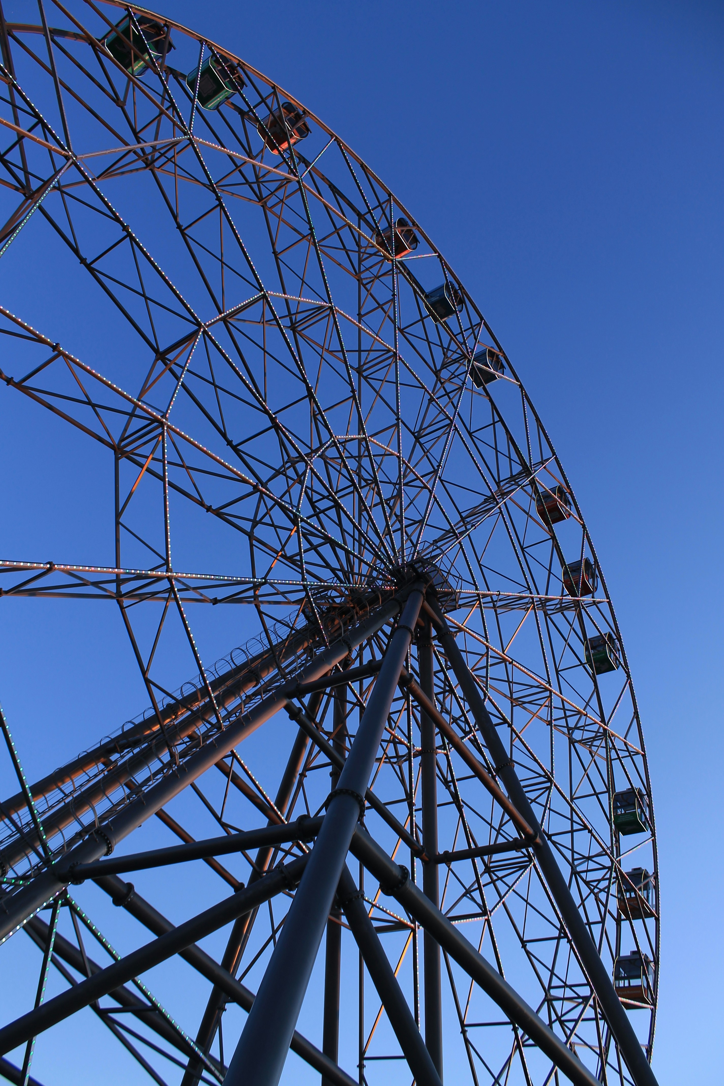 Iron Lattice Against a Cerulean Sky: A Low-Angle Ferris Wheel Portrait
