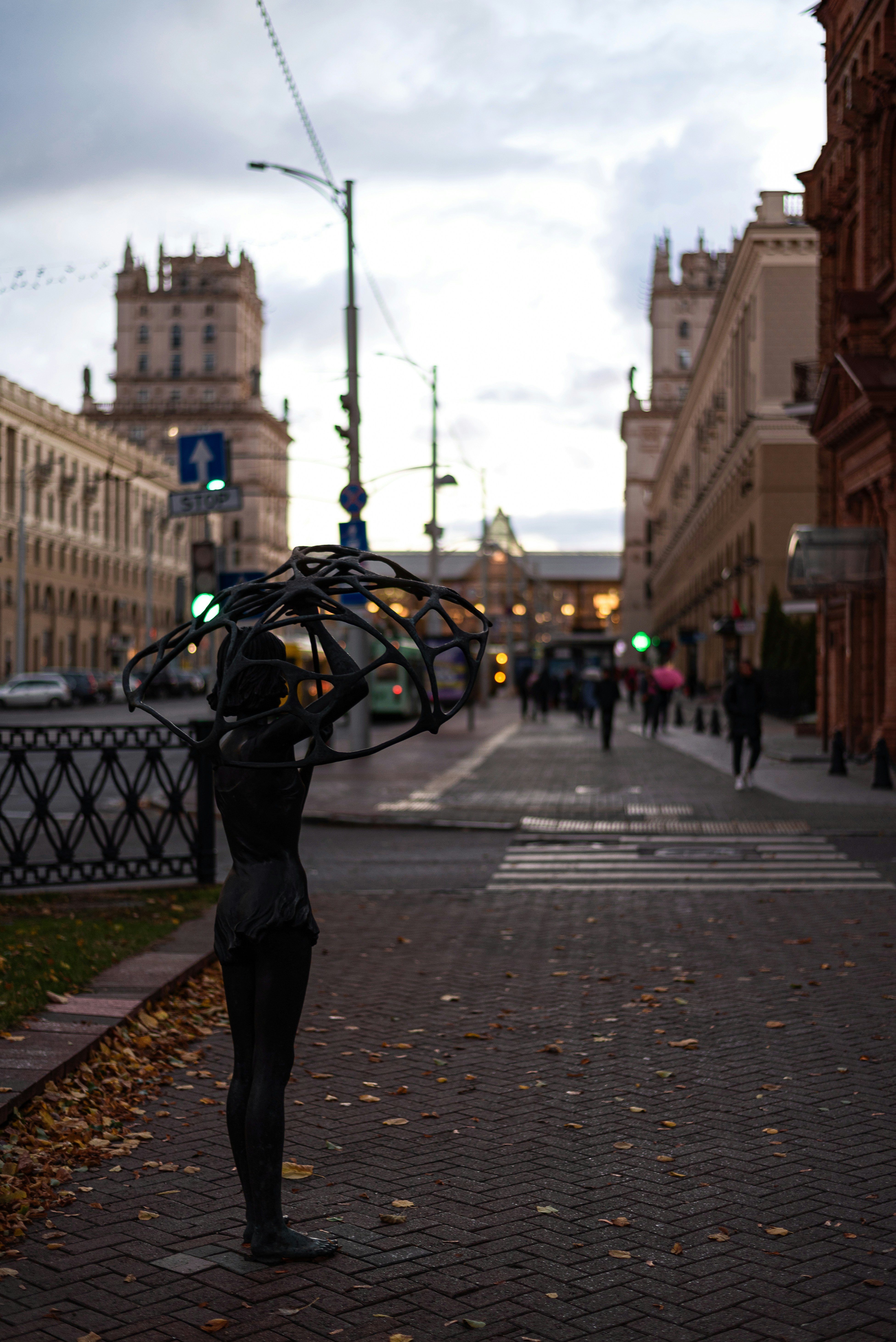 Urban Halo: A Street Performer Elevates a Tangled Steel Sculpture on a City Street
