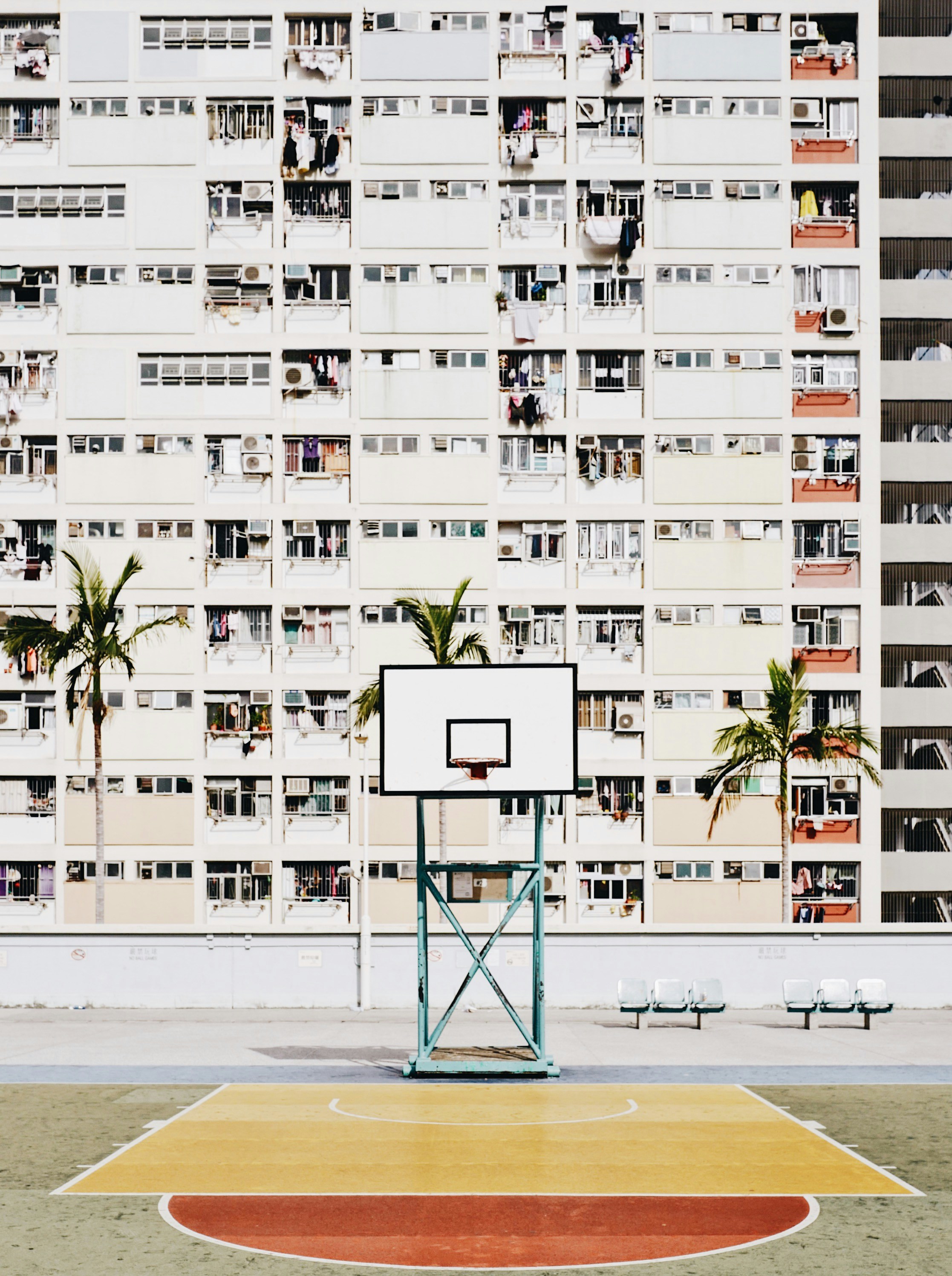 Urban Net: A Basketball Court Framed by Distant Towers