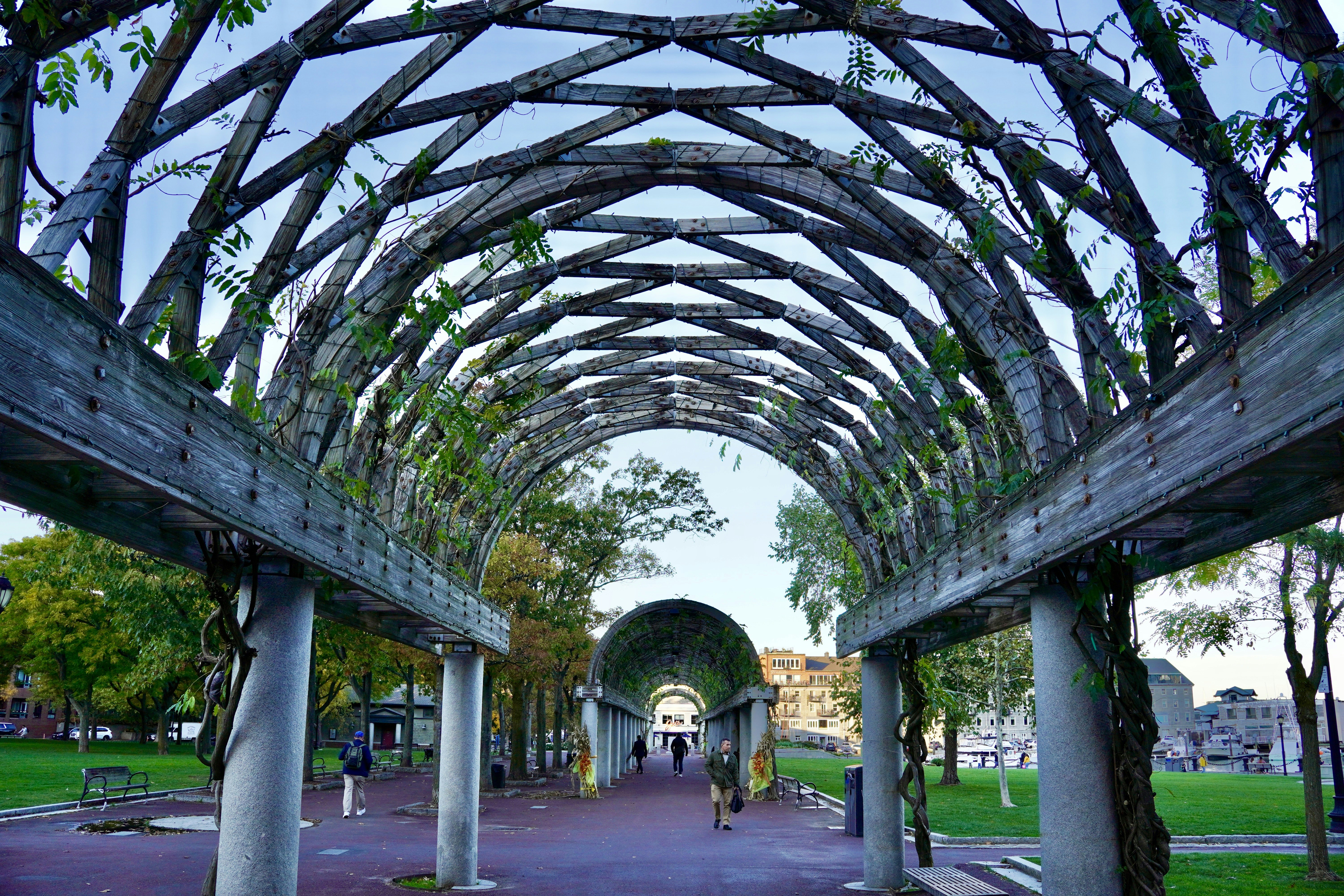 A large metal structure with people walking underneath photo – Free ...