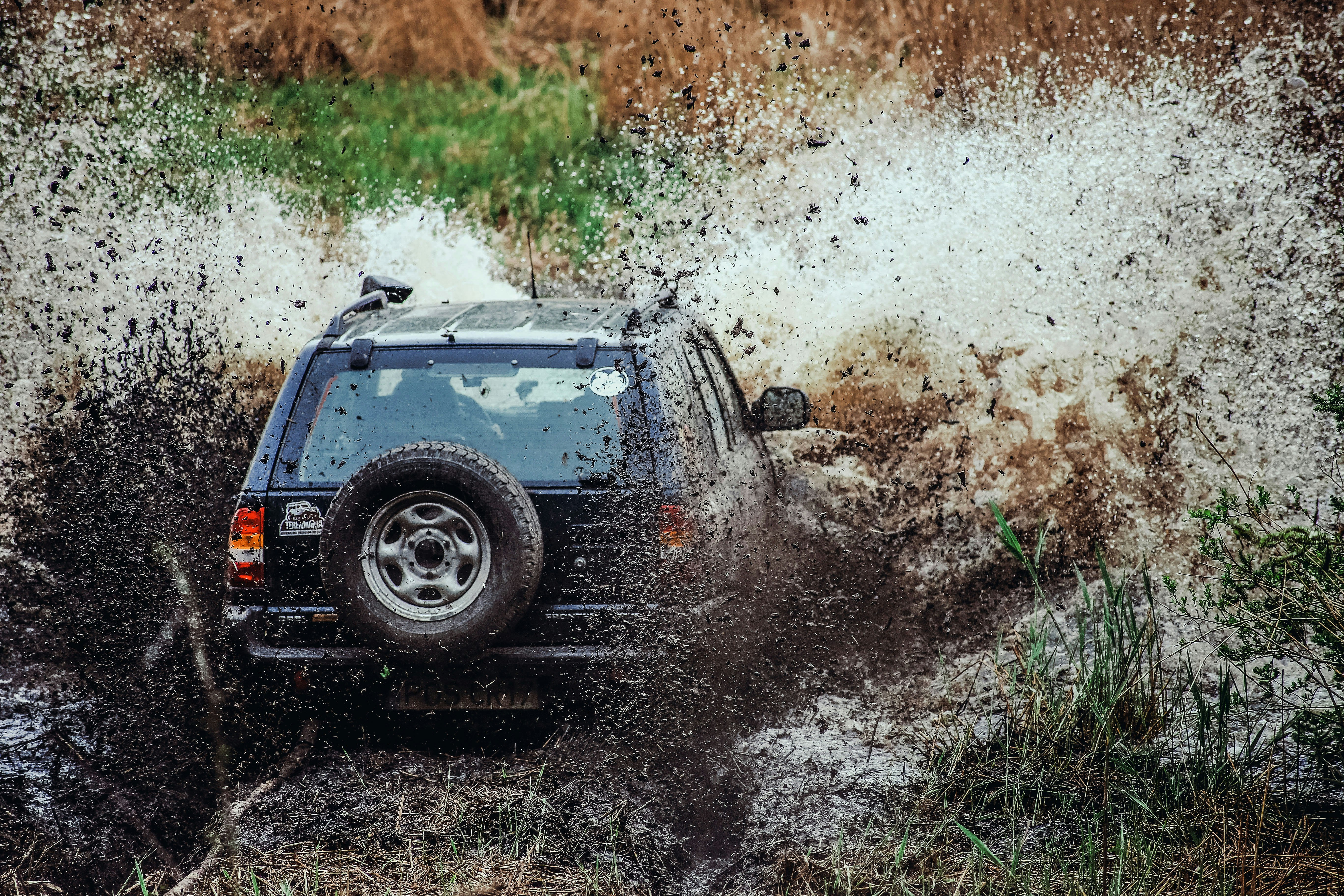 Mud-Splashed Trek: Off-Road SUV Conquers a Water-Choked Trail