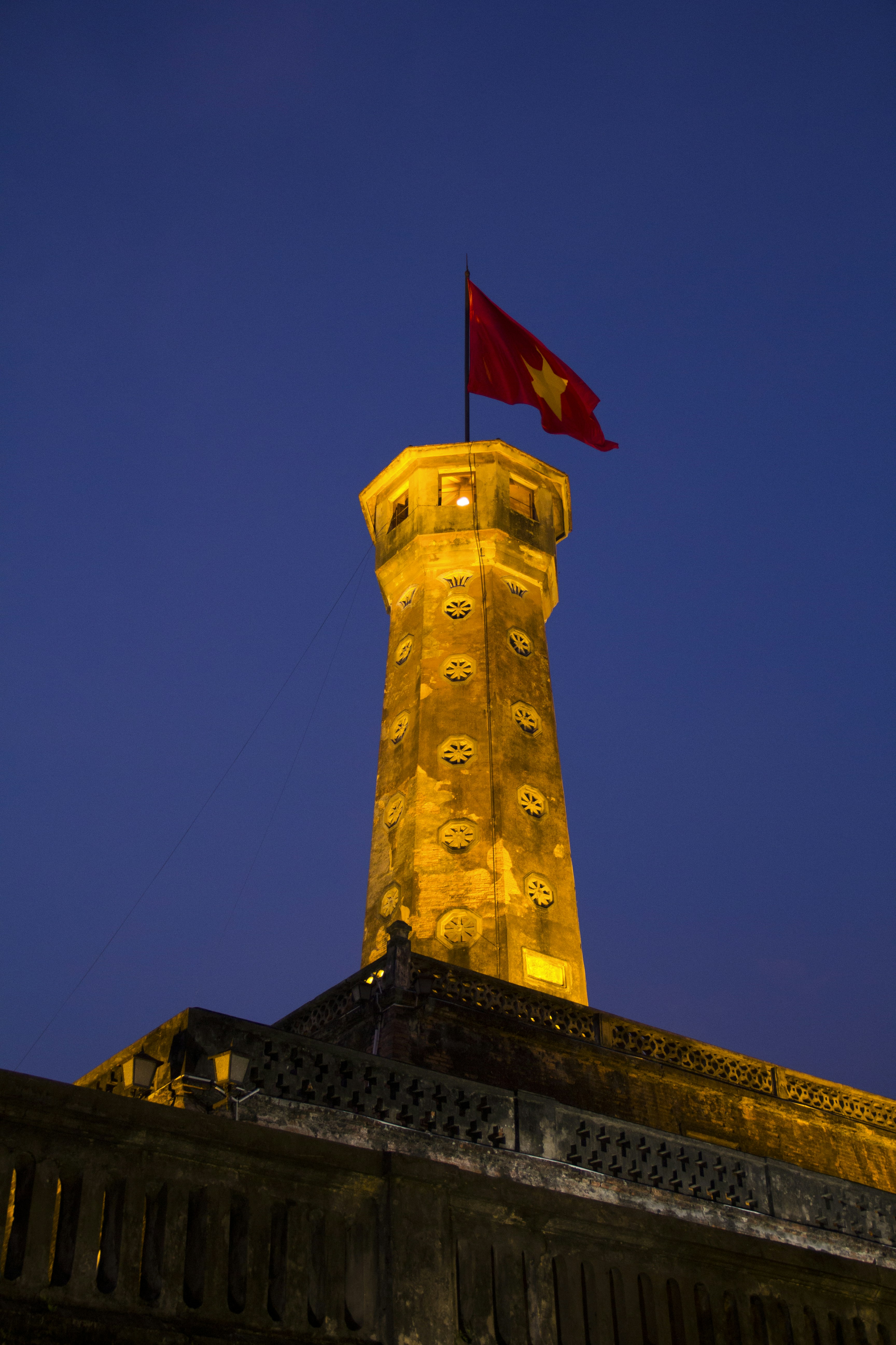 Flag over the illuminated tower: Vietnam War era beacon under night sky