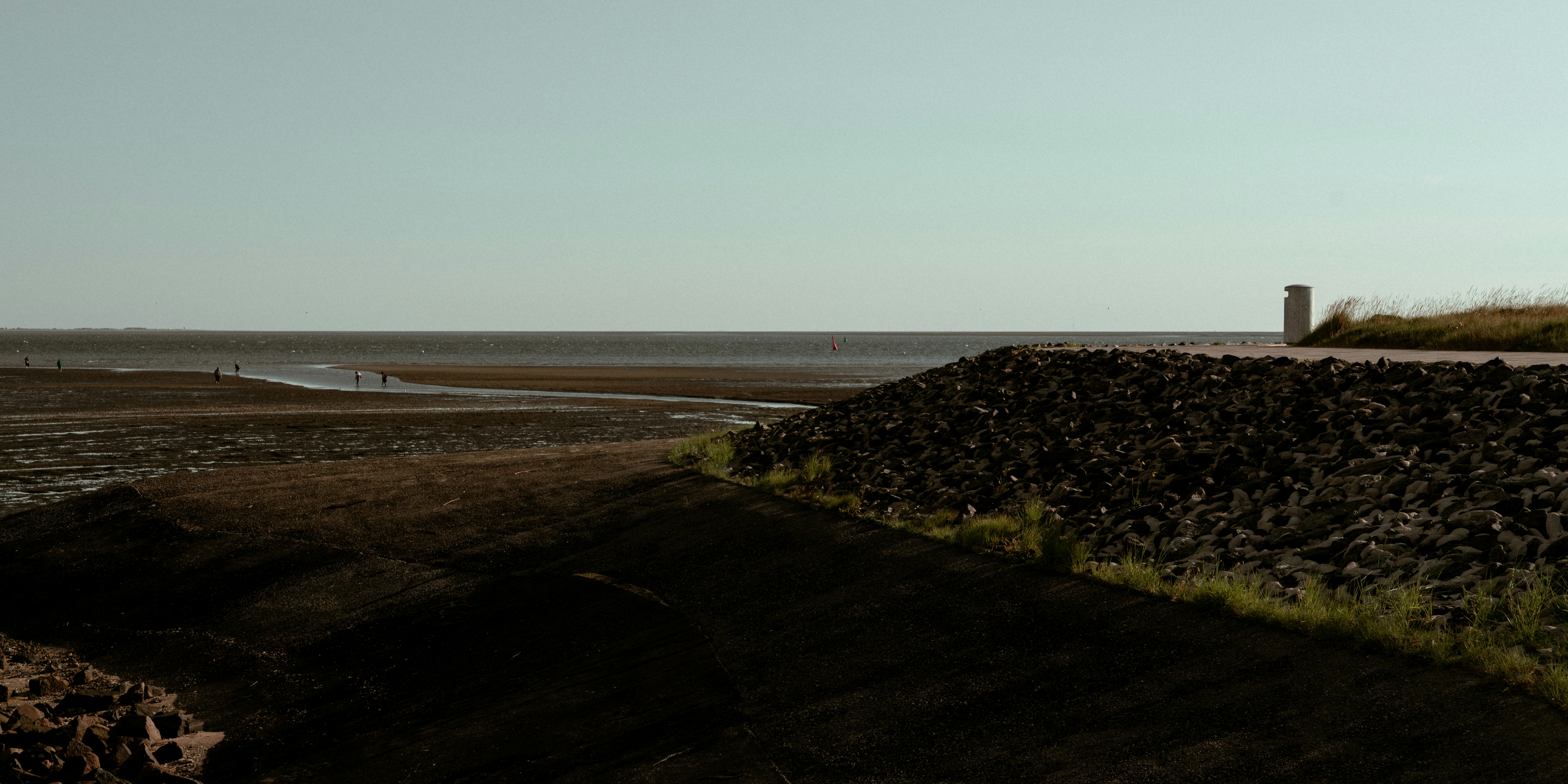 Tide Line and Dune Ridge Beyond a Rocky Breakwater