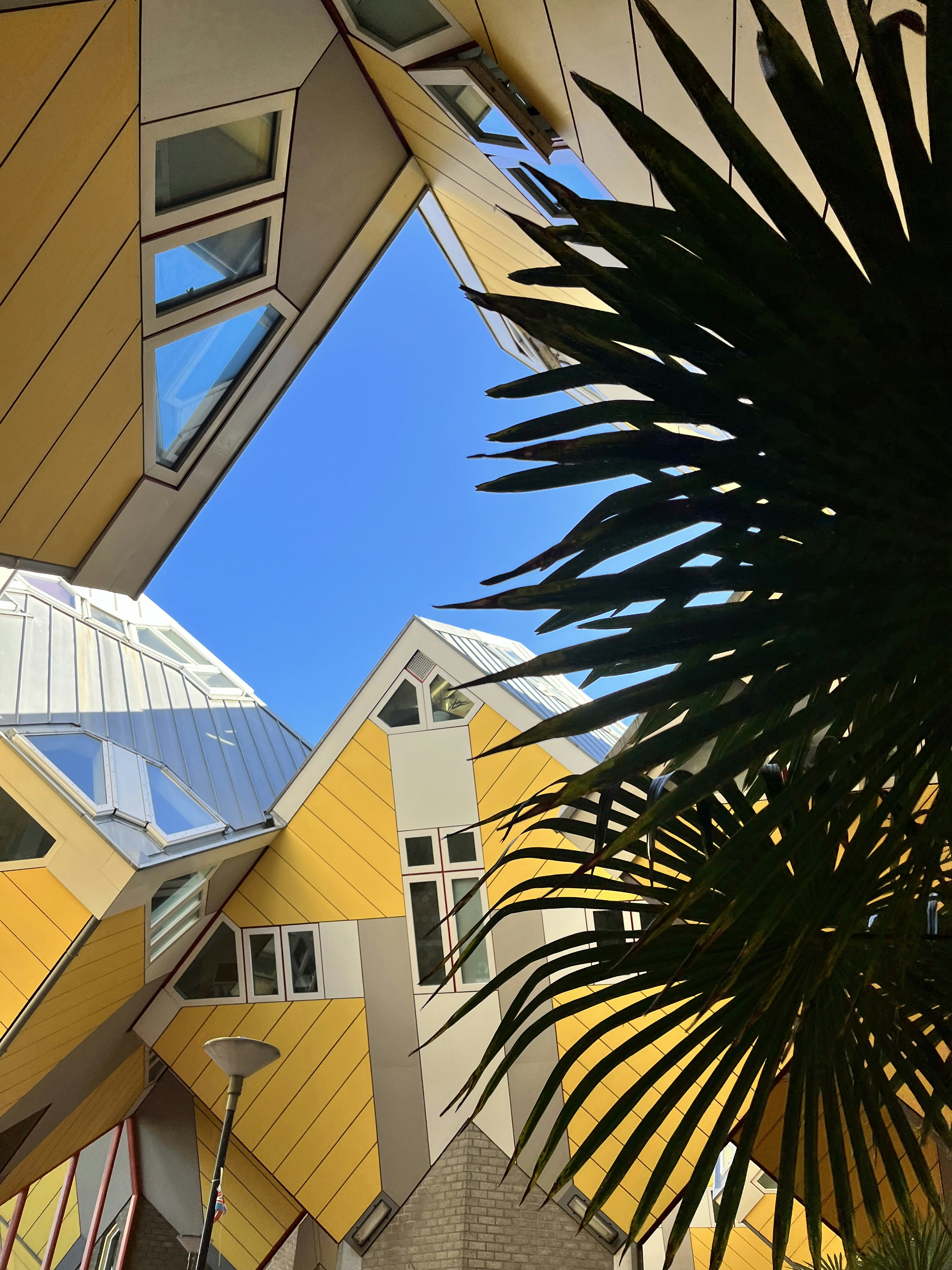 Architectural Kaleidoscope: yellow facets and blue sky through angular facades