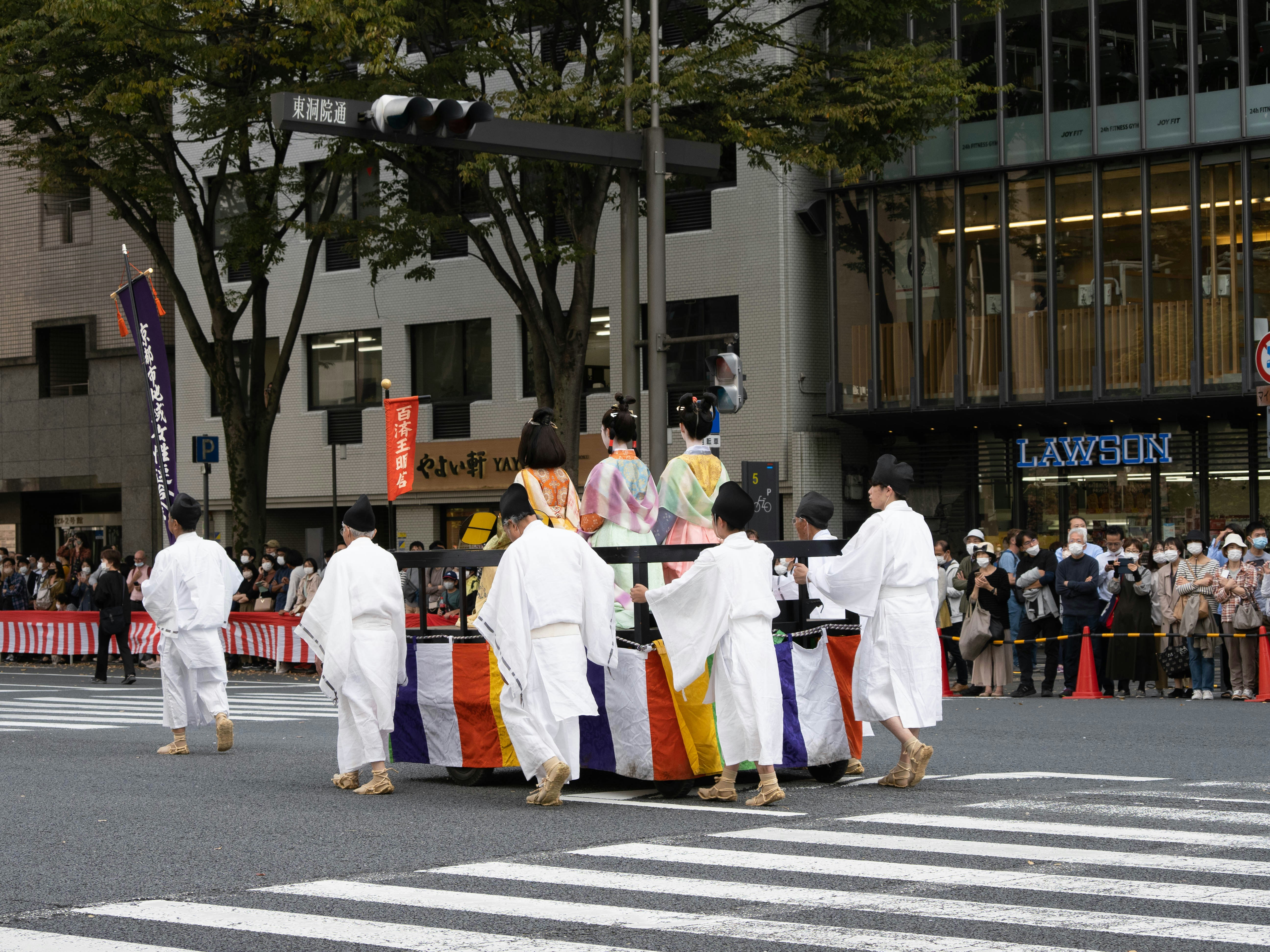A group of people in white robes holding a banner in front of a crowd ...