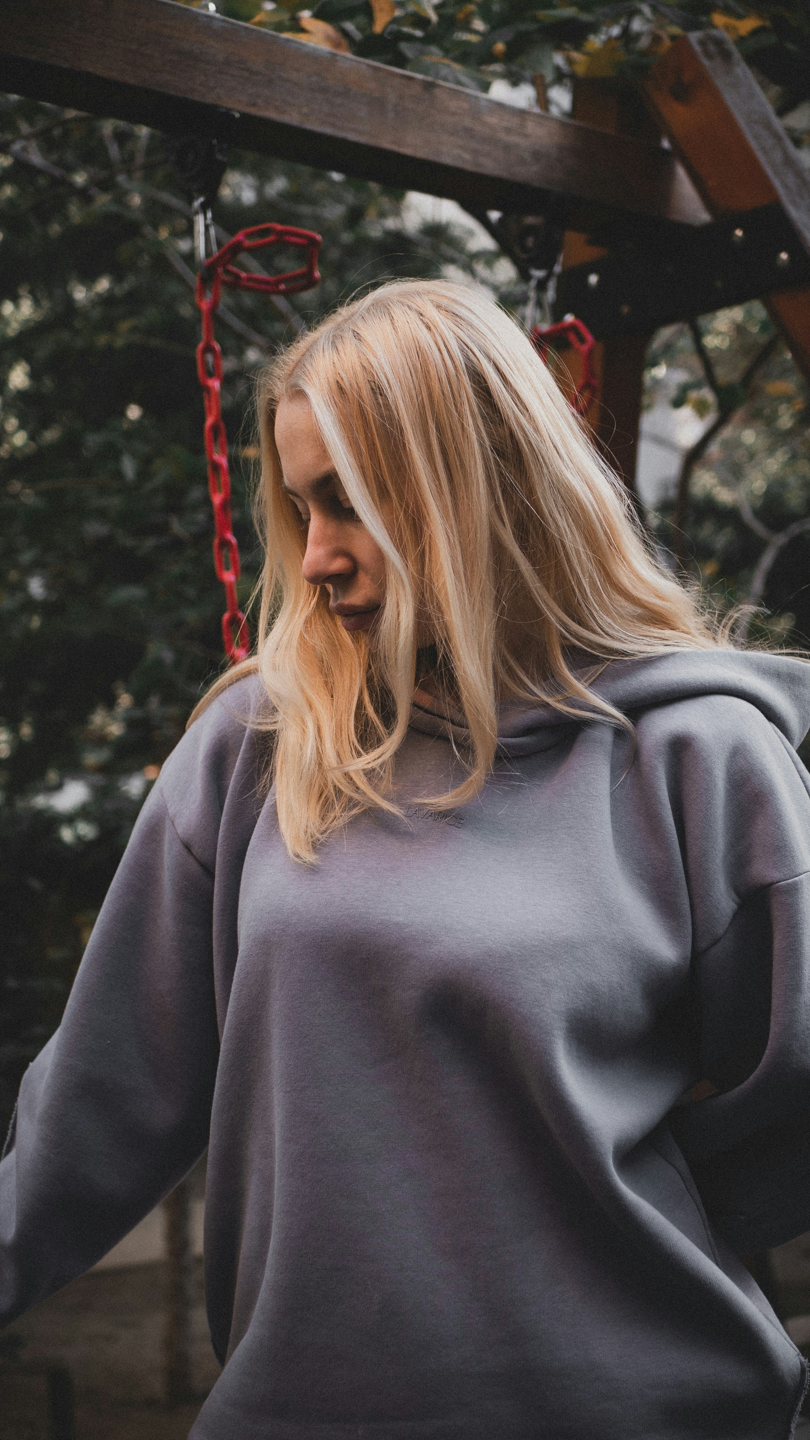 Gray Hoodie, Red Chains: A Contemplative Portrait in Dappled Light