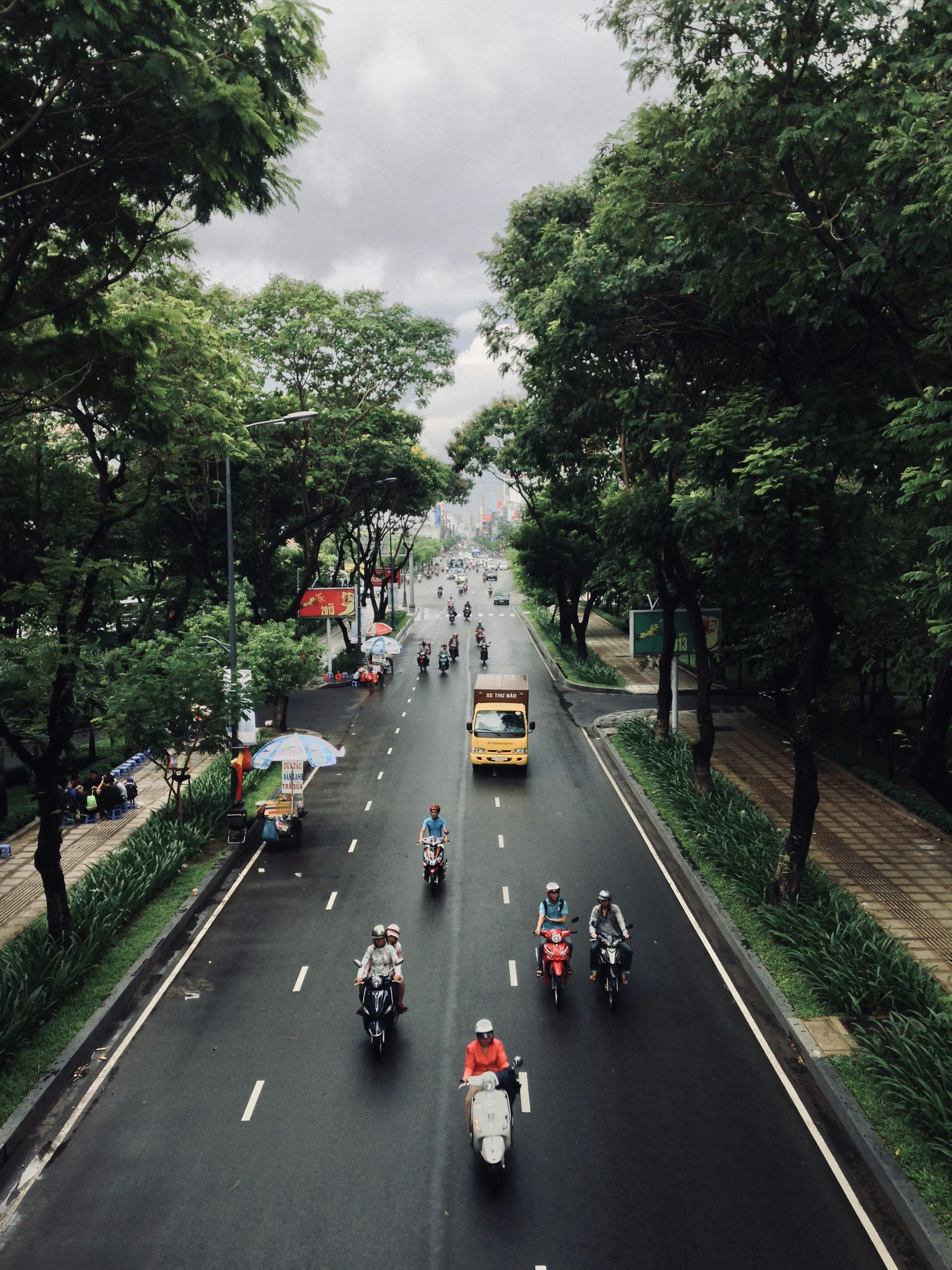 a group of motorcyclists ride down a street