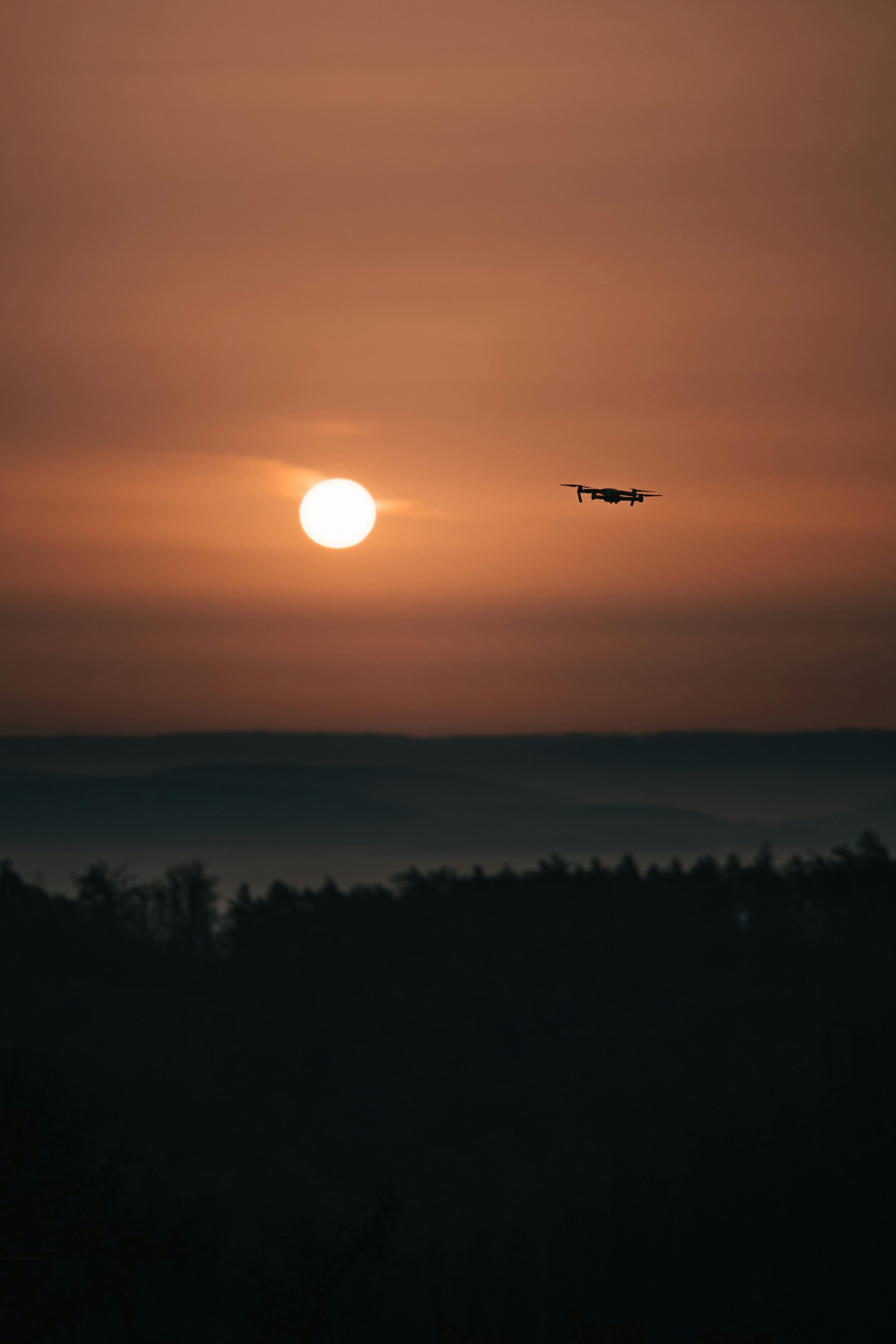 Sunset Drone Crossing: A Quiet Horizon with a Flying silhouette
