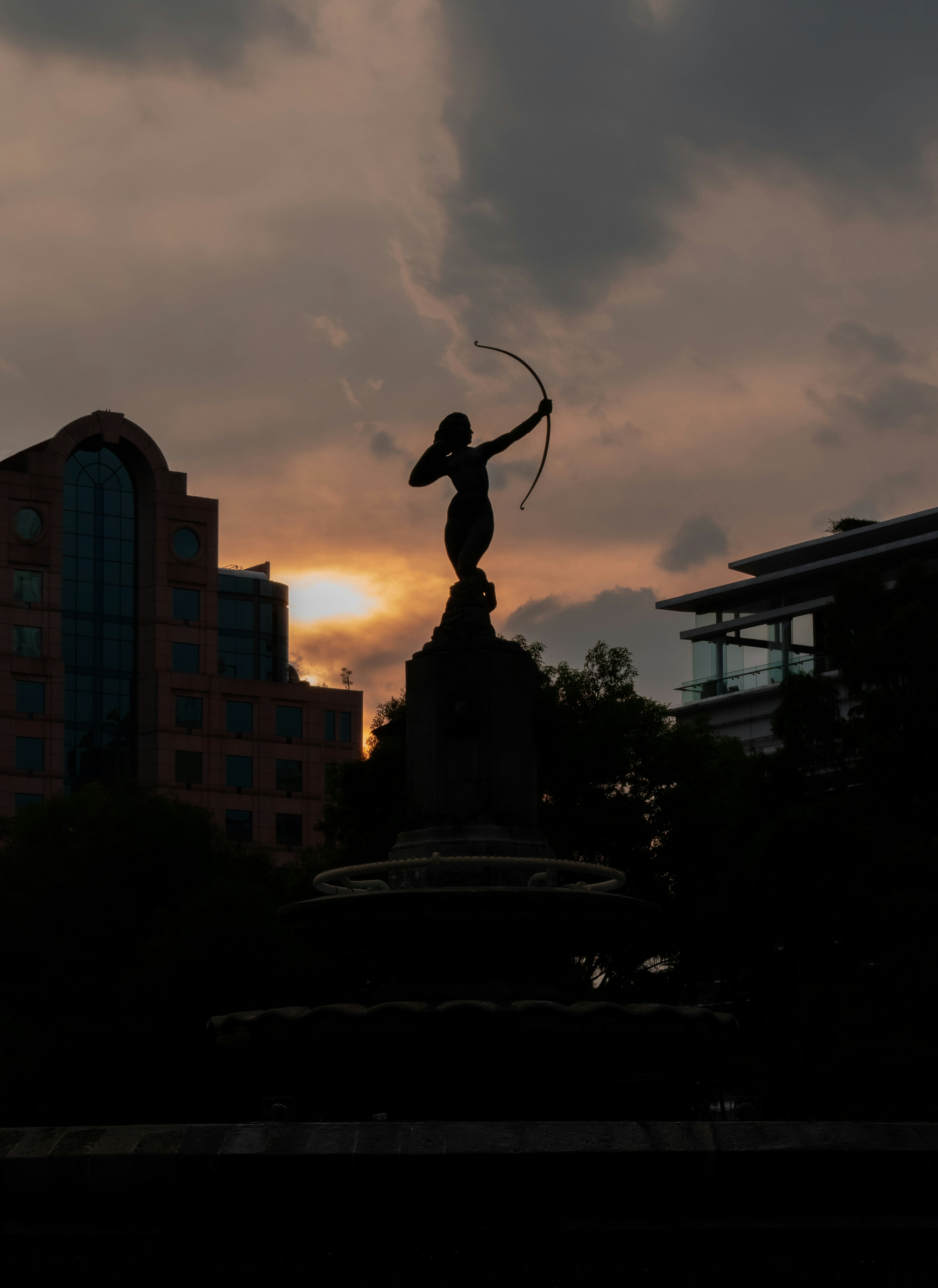 a statue of a person holding a sword in front of a building