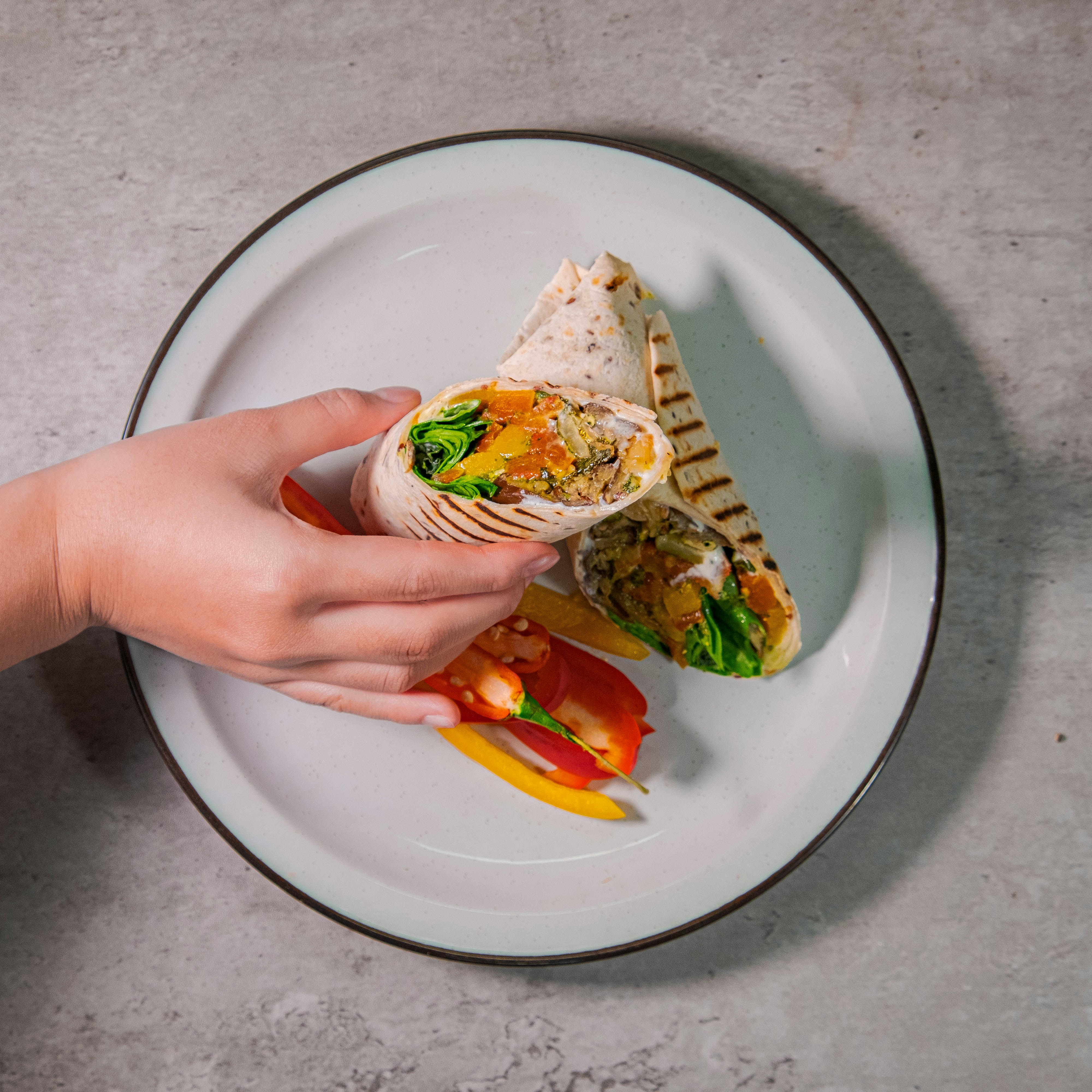 Handful of Veggie Wraps: Fresh Fillings Unfold on a White Plate