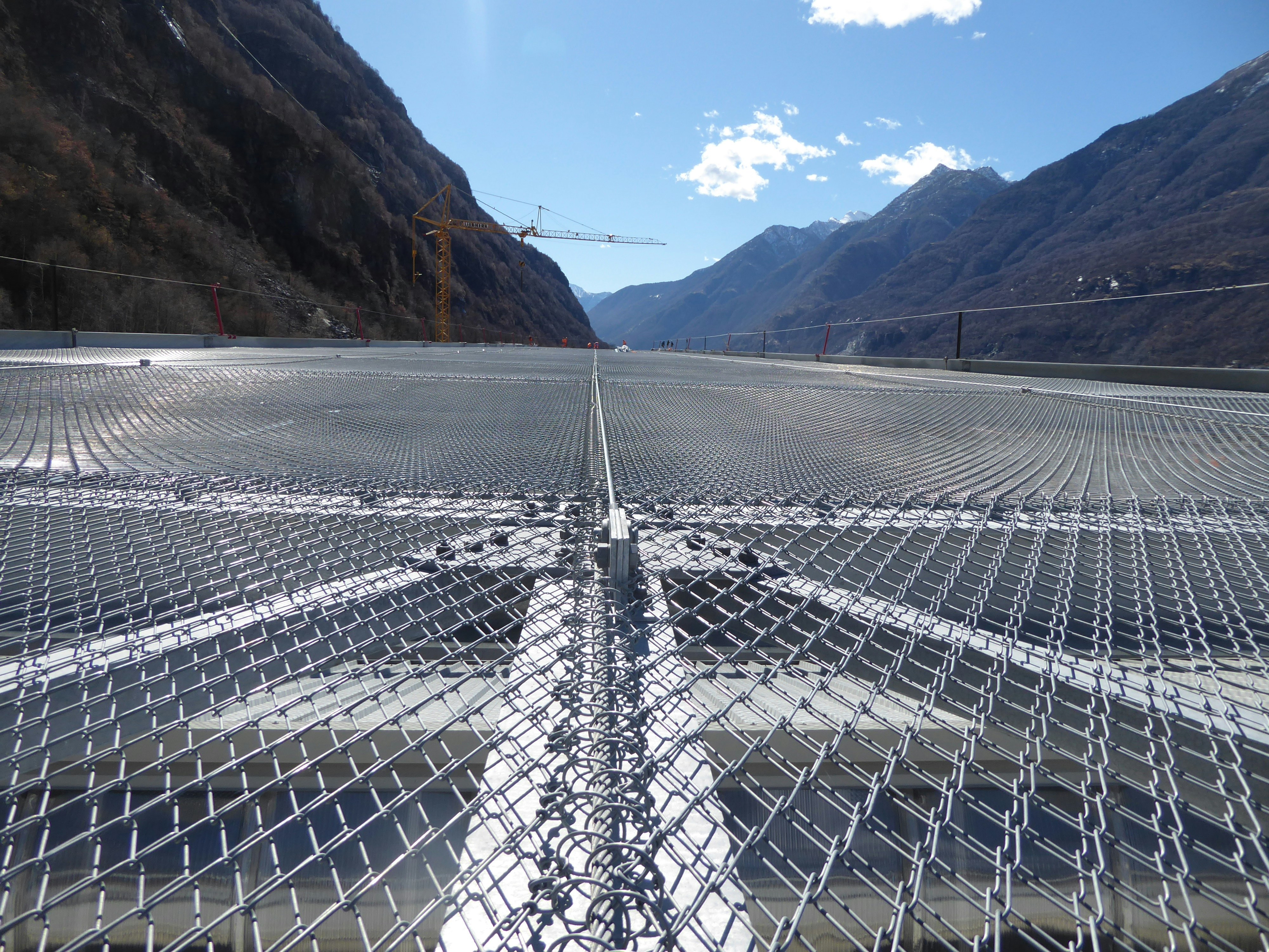 Highwire Crossroads: A Chain-Link Bridge Reaches into Alpine Distance