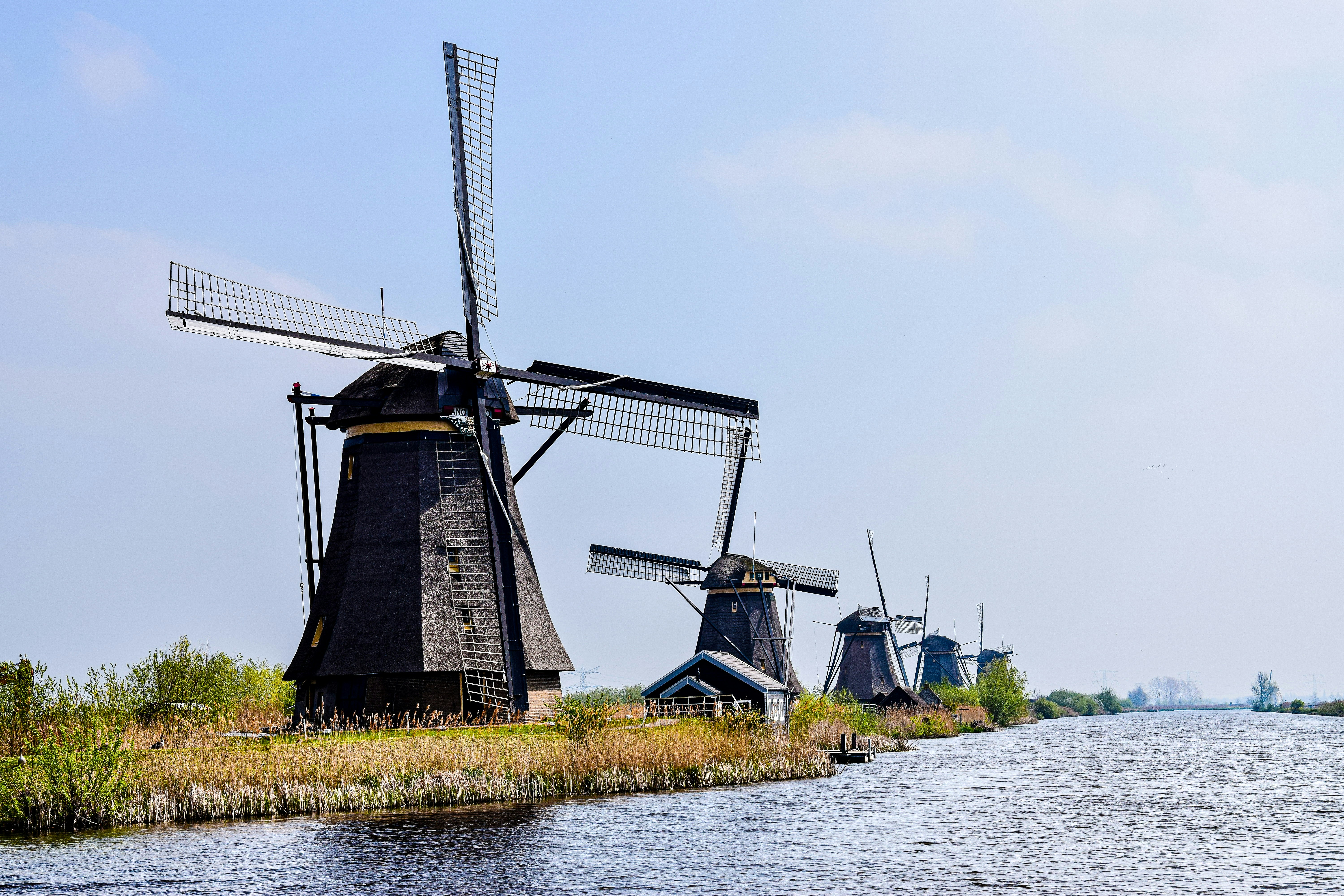 A windmill next to a body of water photo – Free Netherlands Image on ...