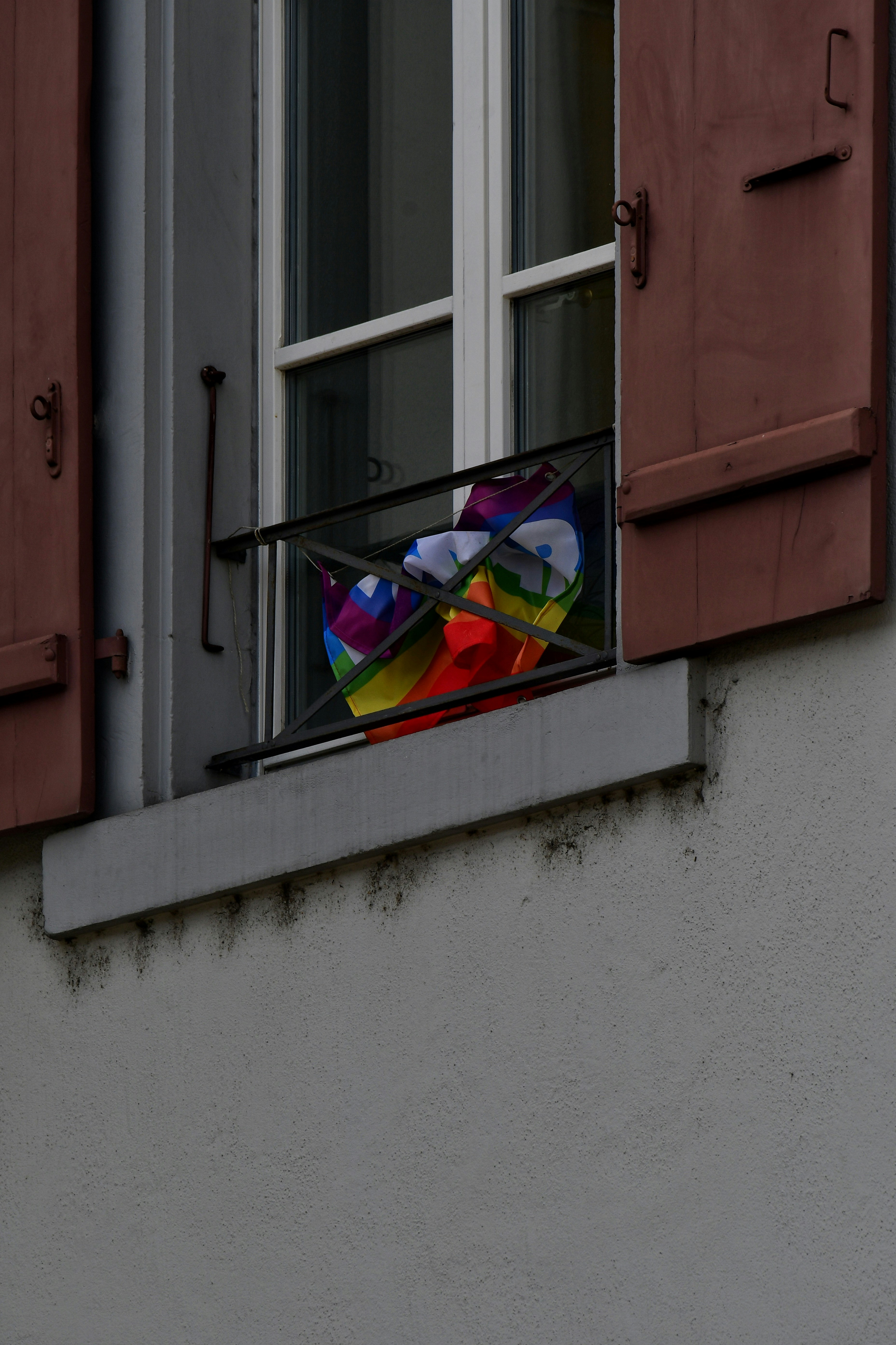 Prism Behind the Shutter: Pride Flag Peeks Through a Window