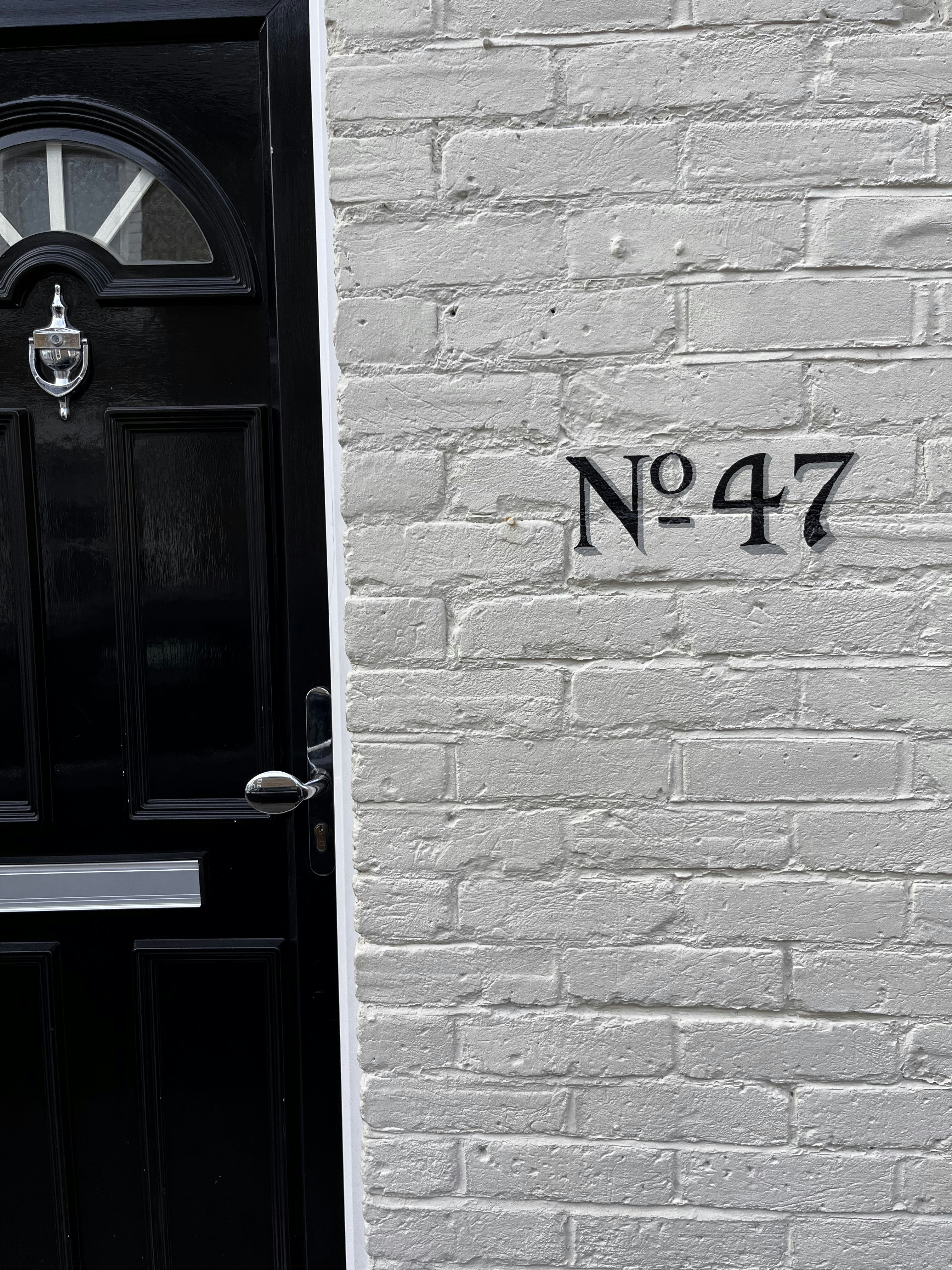 No. 47: A Black Door Framed by Pale Brick