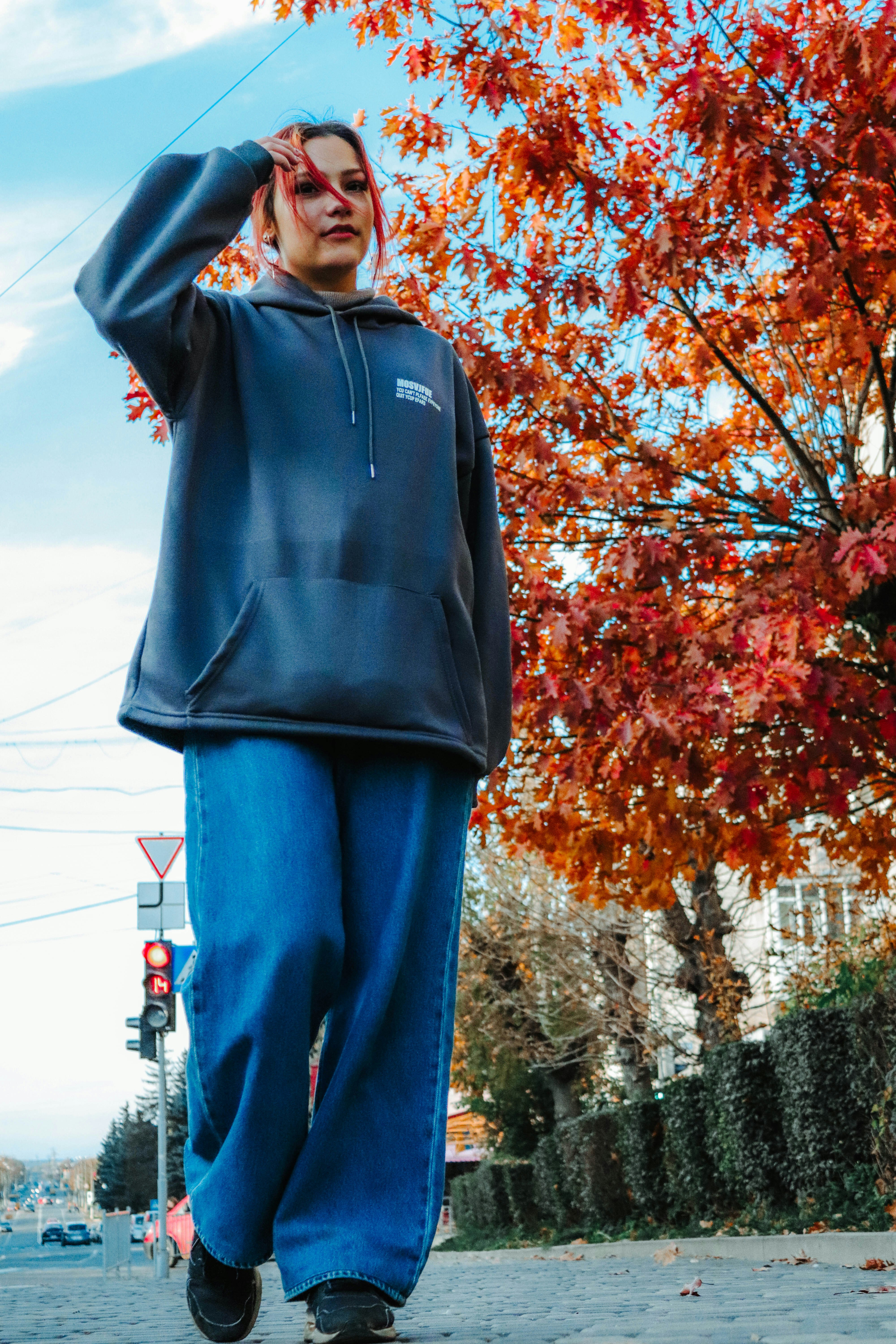 Autumn's Quiet Giant: A Street Portrait in an Oversized Blue Hoodie