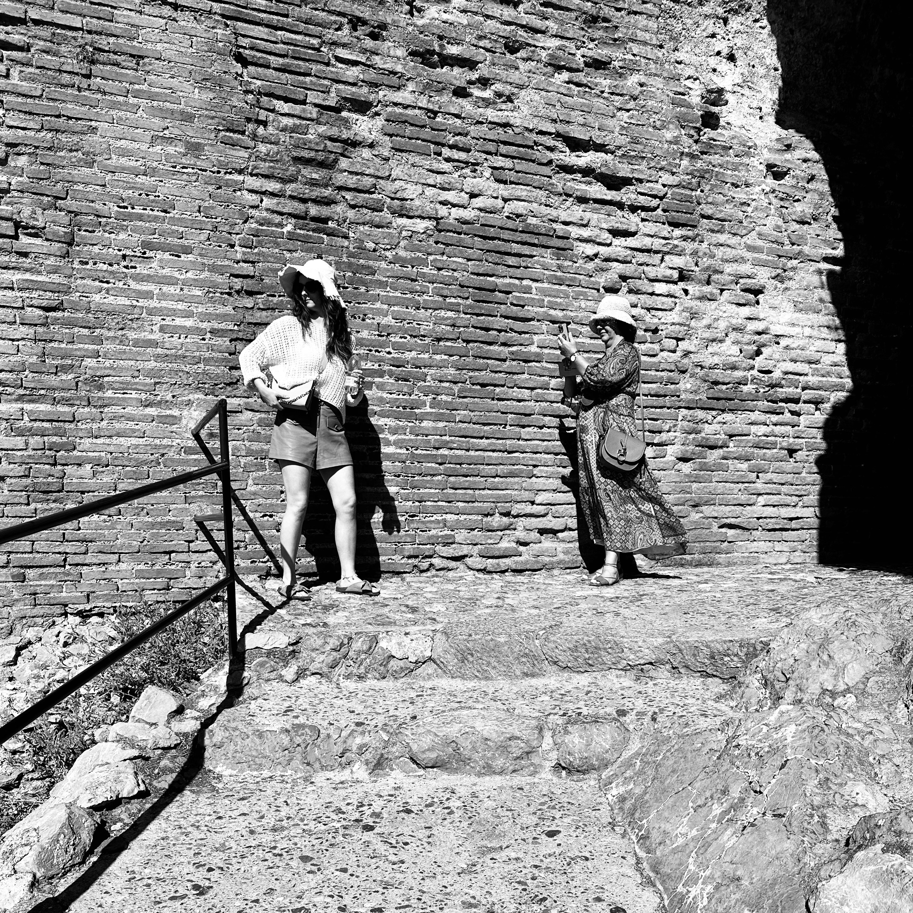 a group of people standing on a stone wall
