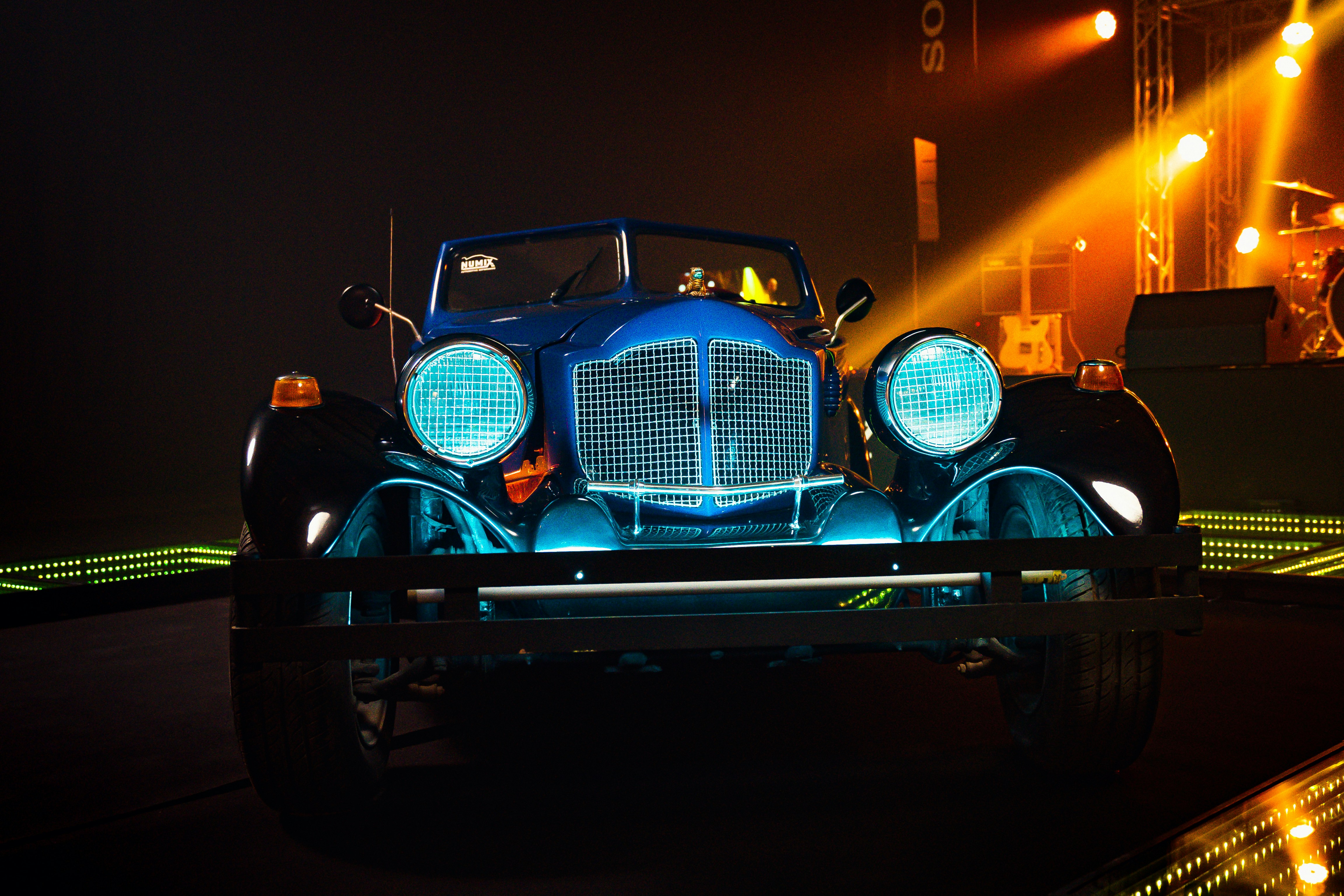 Blue Chrome on Stage: Vintage Roadster Dominates Neon Spotlight