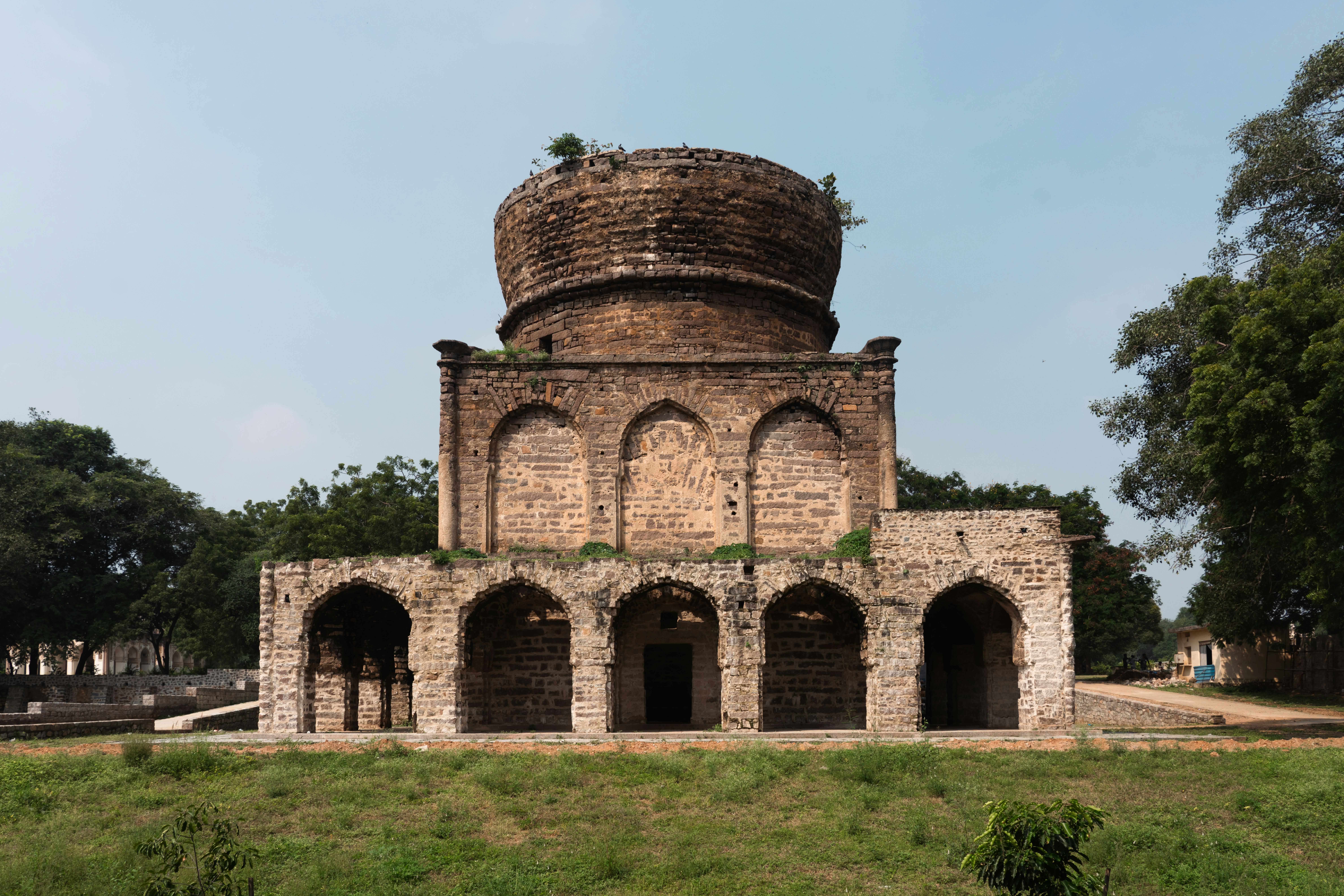 Historic stone structure with arched openings set against a clear sky.