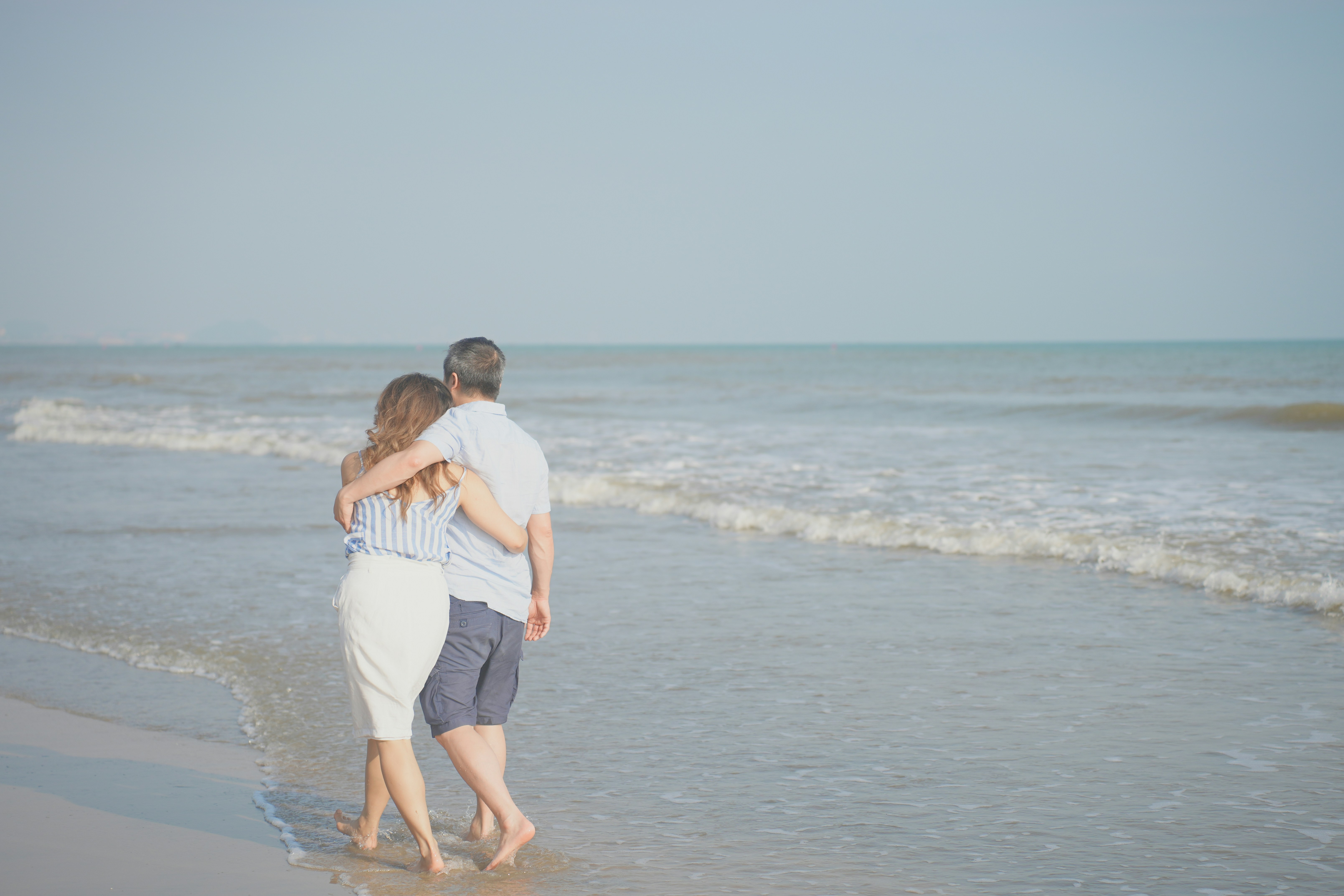 Foto zum Thema Ein Mann und eine Frau küssen sich am Strand ...