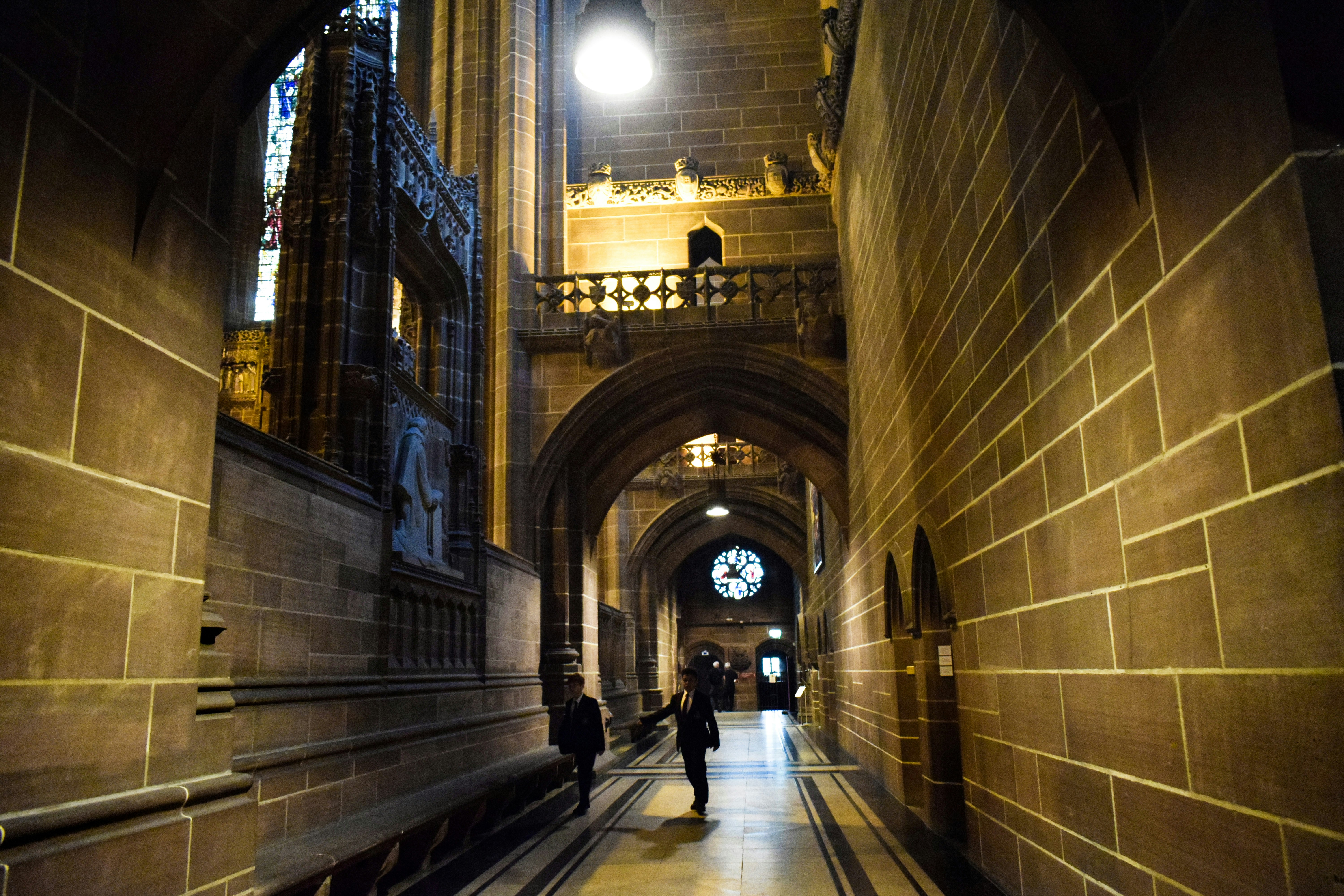 A group of people walking down a hall way photo – Free Street Image on ...