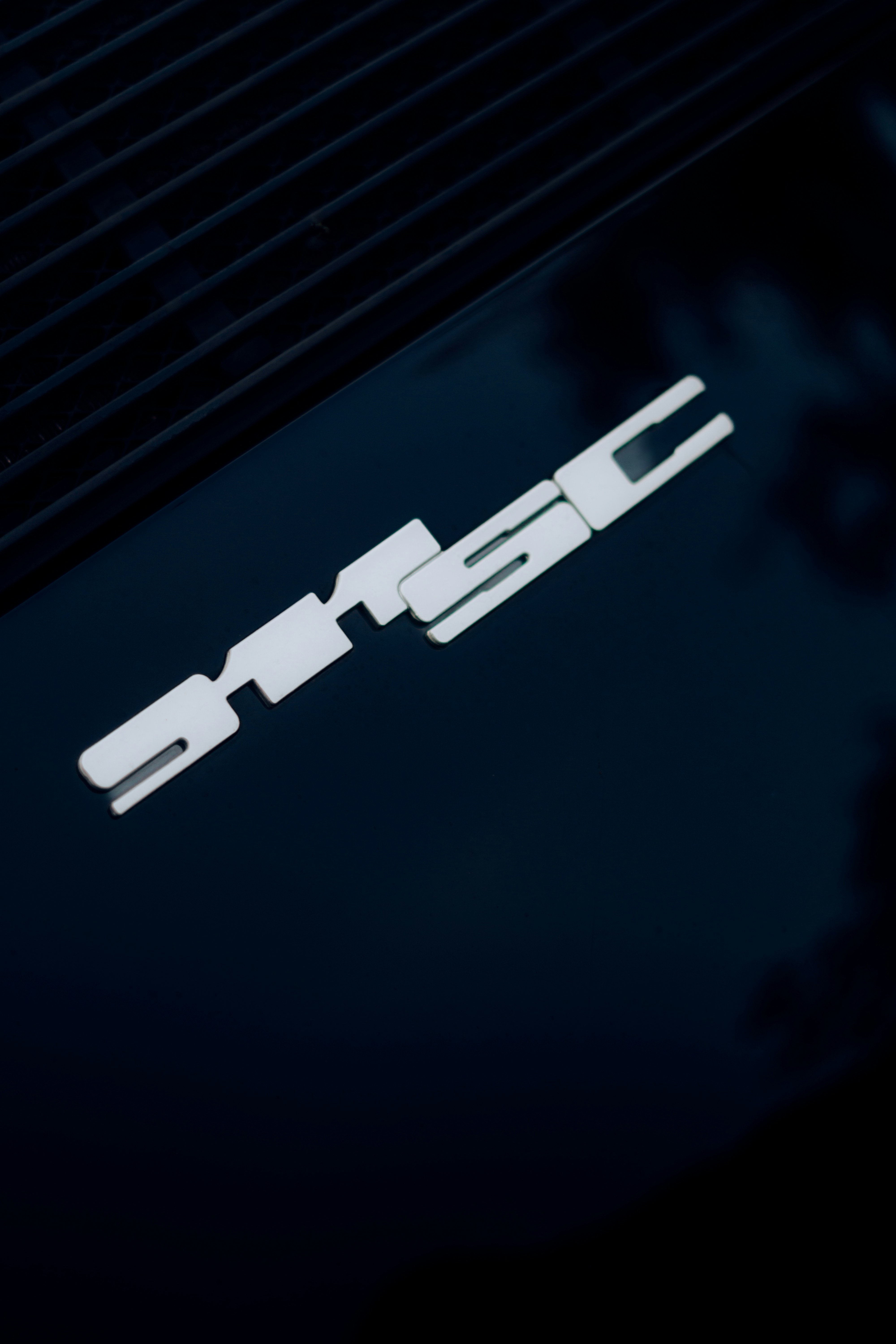 White Chrome Emblem Adorning a Midnight-Blue Car Hood