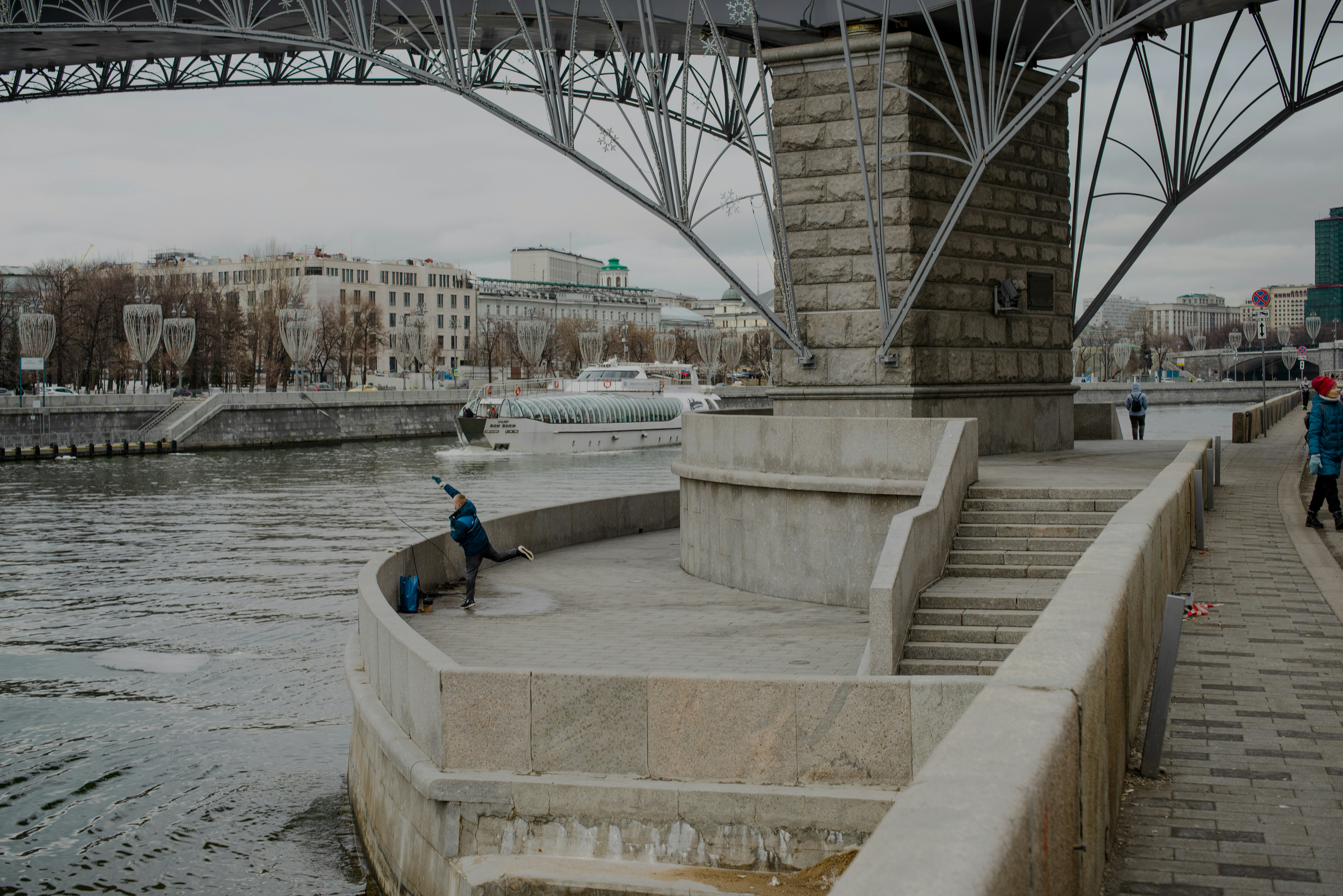 a person sitting on a bench by a river