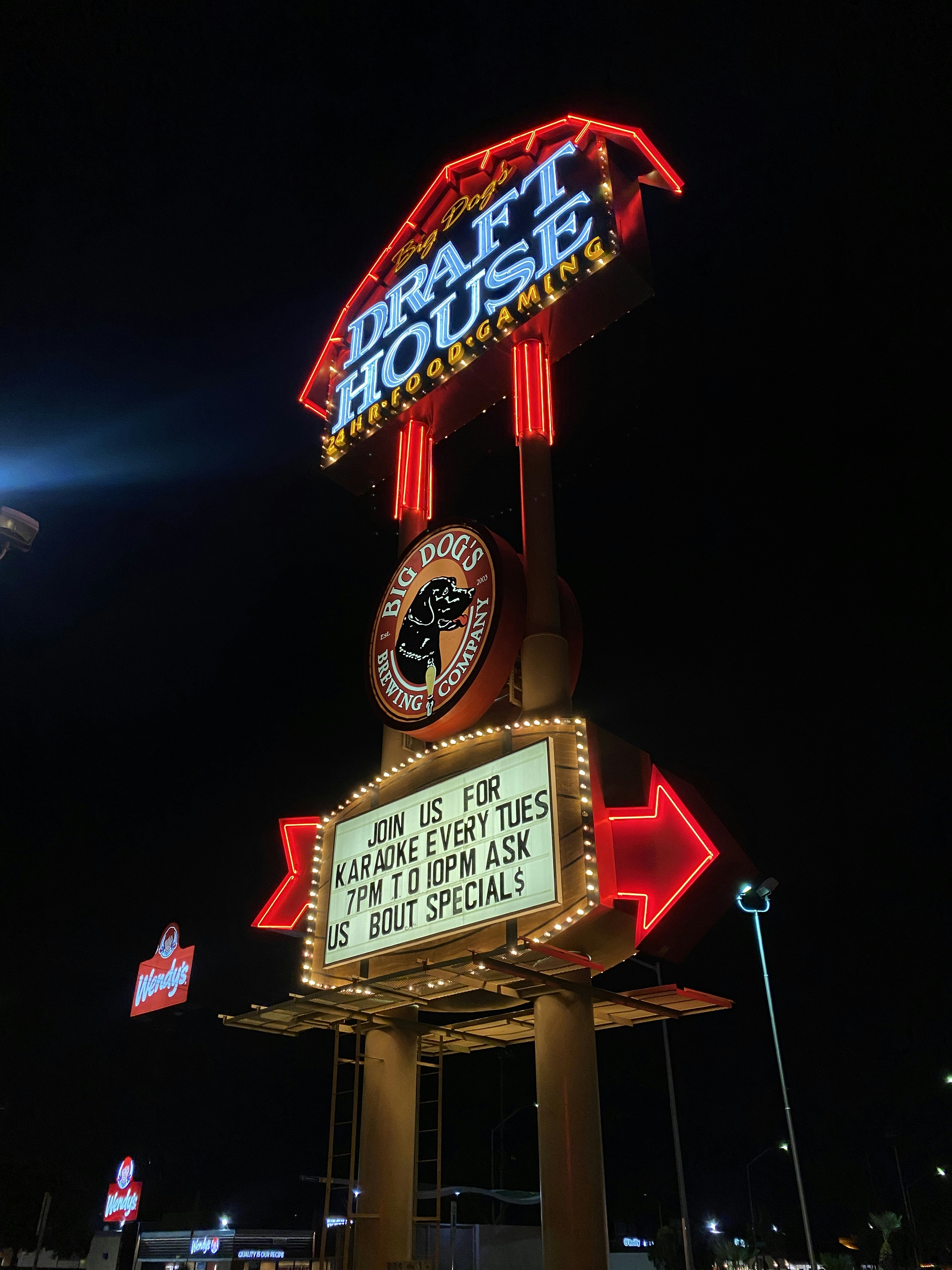 Neon Beacon at Night: The Draft House Sign Tower Illuminates the Street