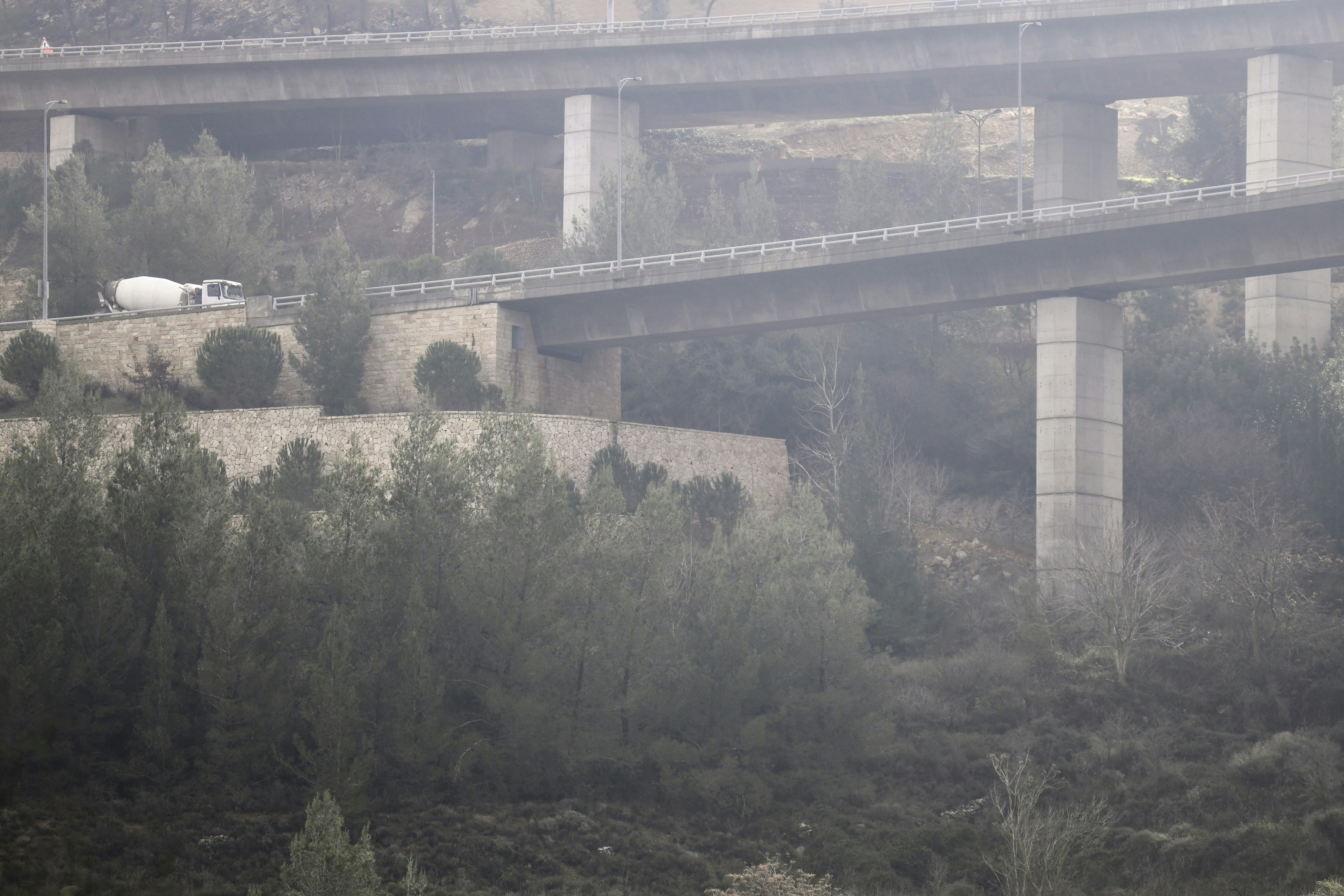 Misty Overpass: A lone tanker on a cliffside bridge