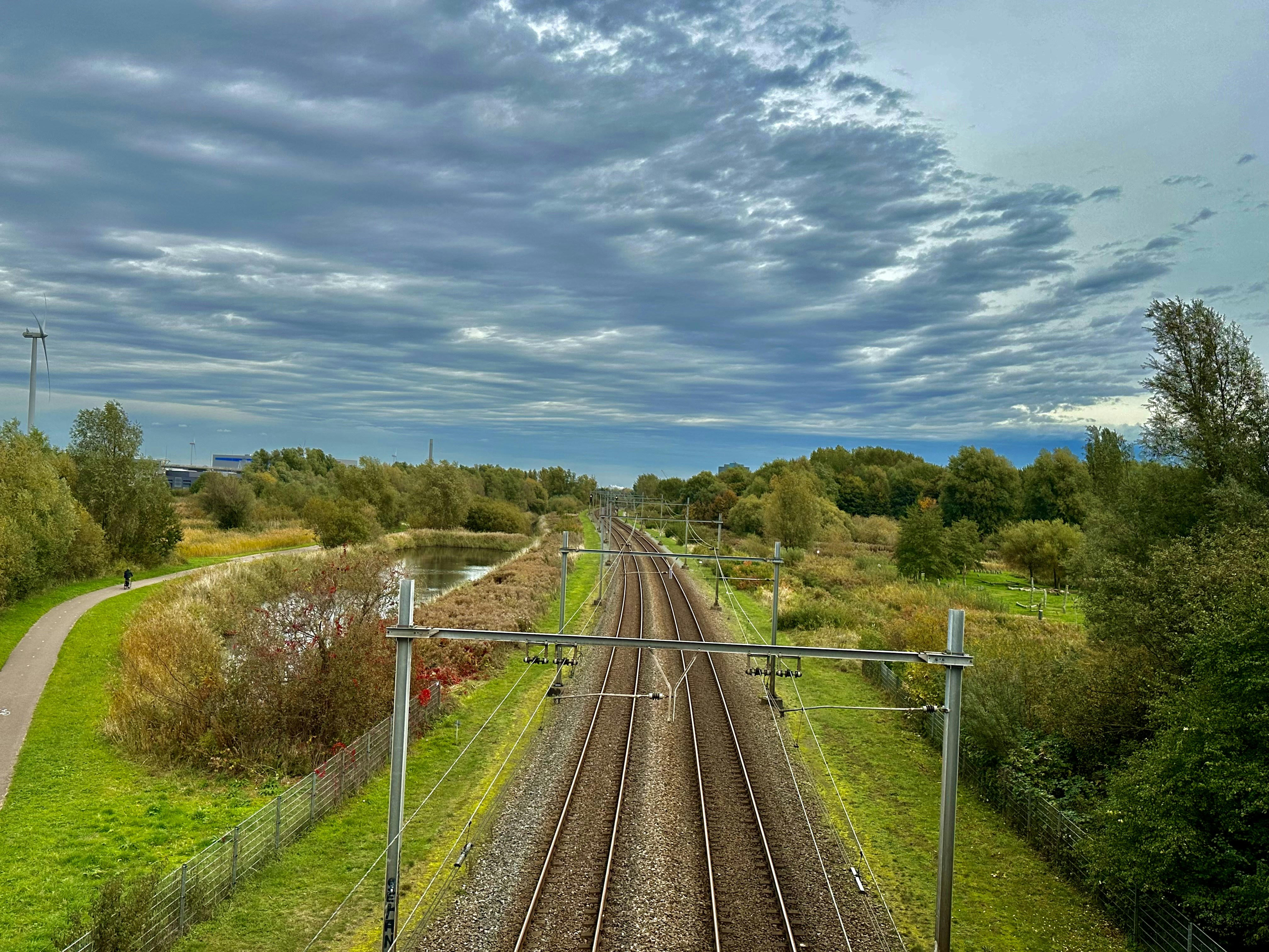 Converging Rails Under a Layered Autumn Sky