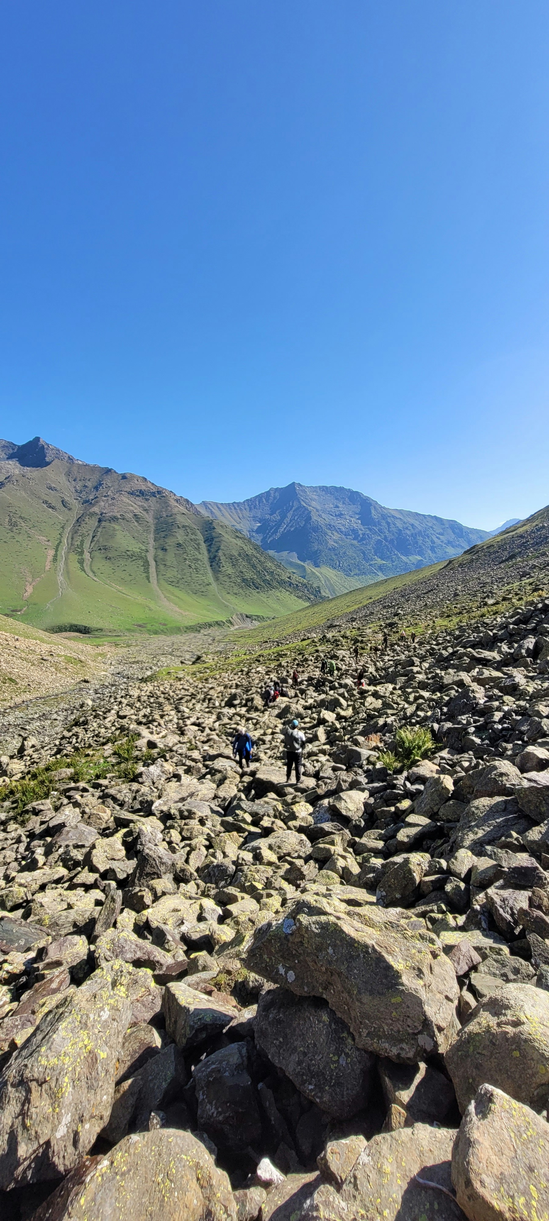 A group of people walking on a rocky path in a valley photo – Free ...