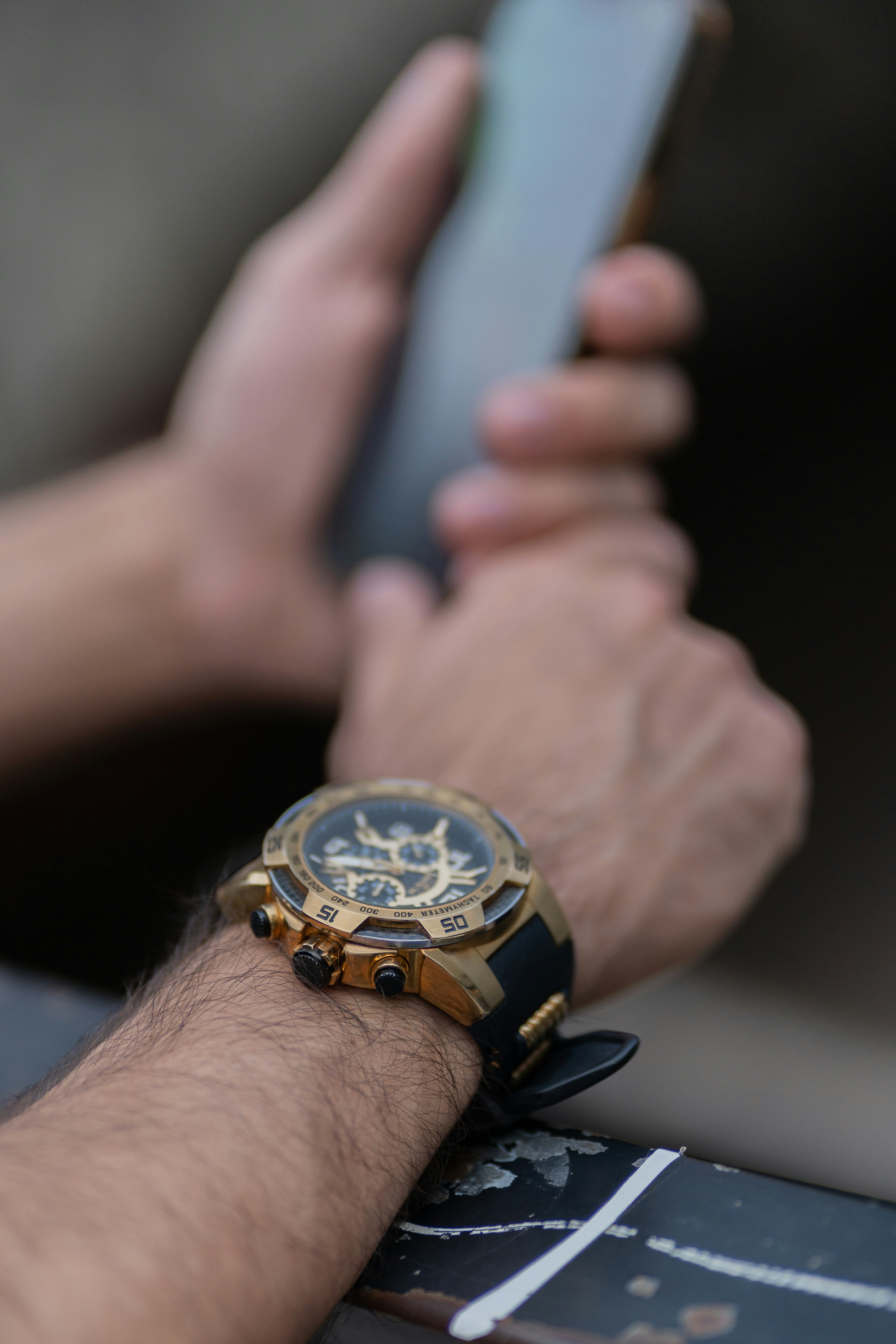 Gold Chronograph on a Gripped Wrist: Timekeeping Meets a Touchscreen