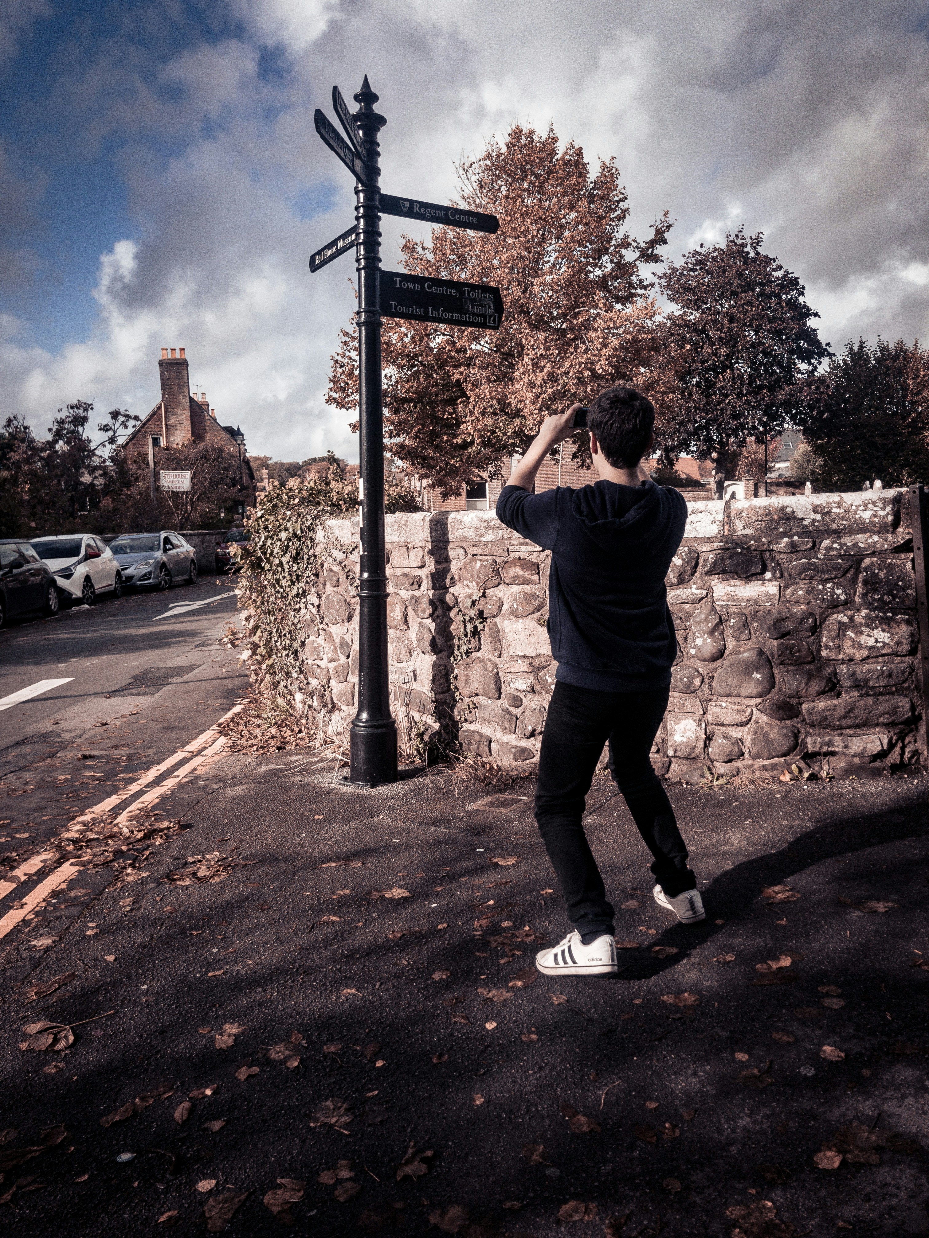 A person standing next to a street sign photo – Free Apparel Image on ...