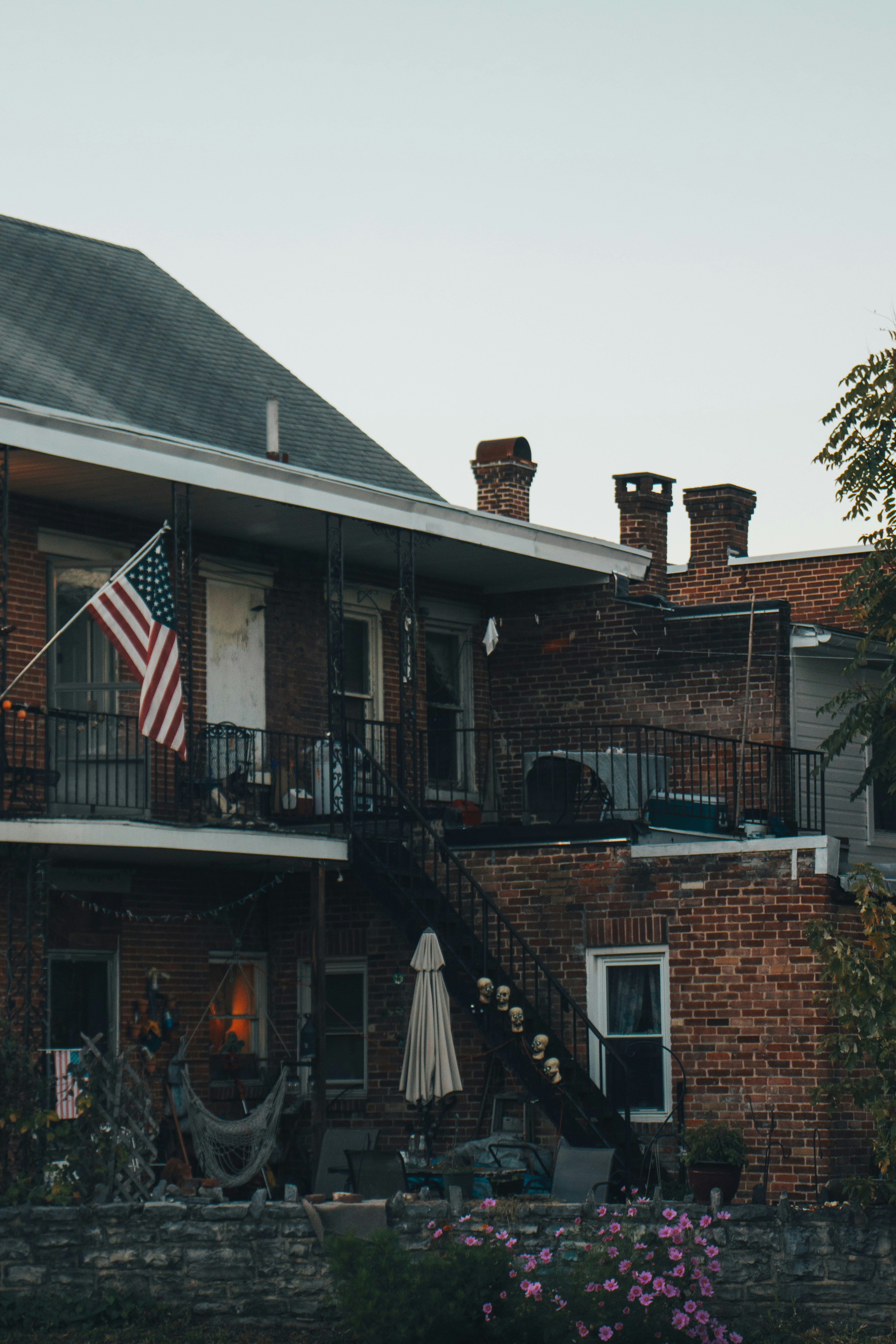 Flag Over the Brick Terrace: Evening Light on a Multilevel Home