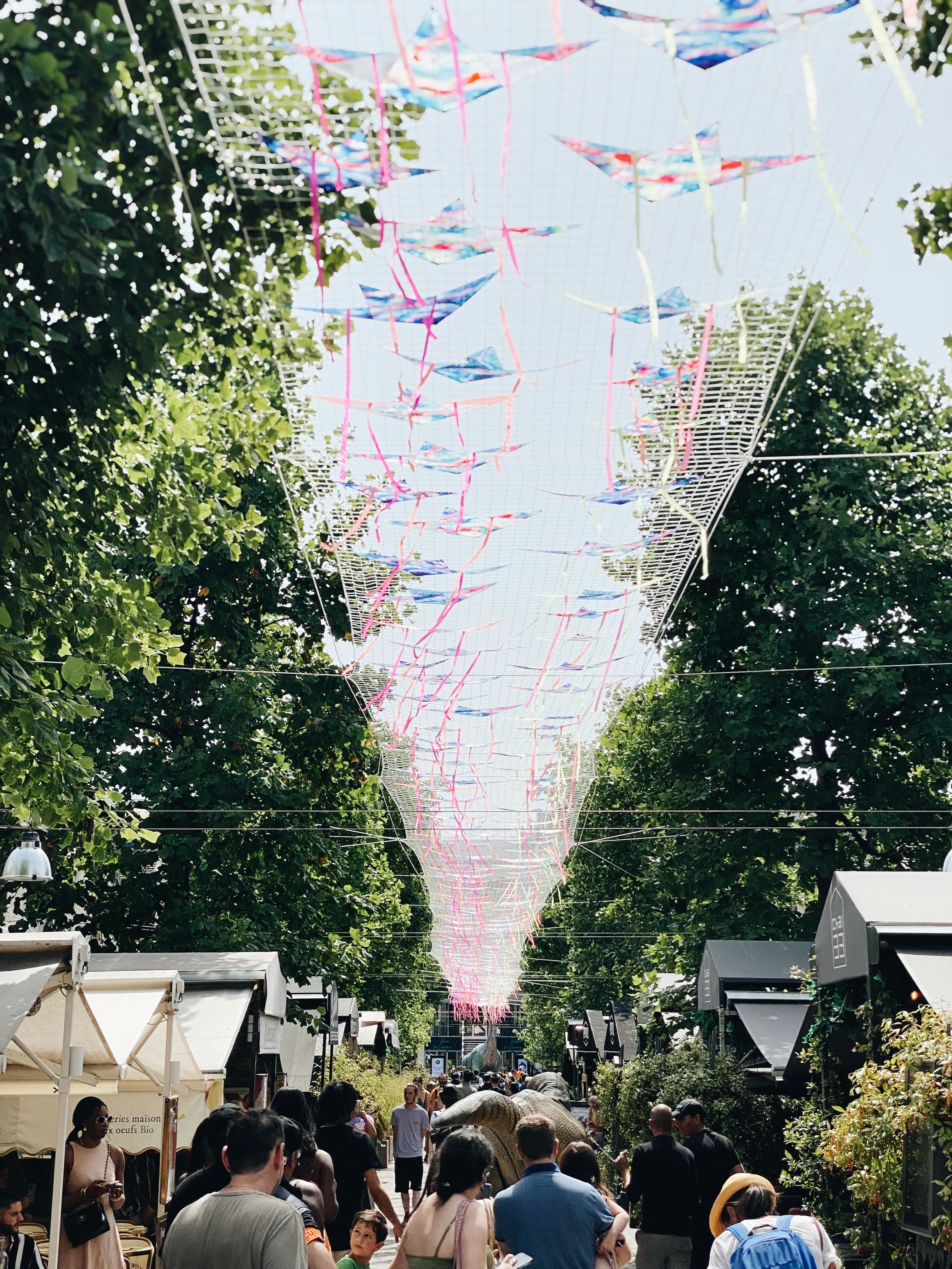 Festival Corridor: Color Flags Loom Over a Crowded Market Street