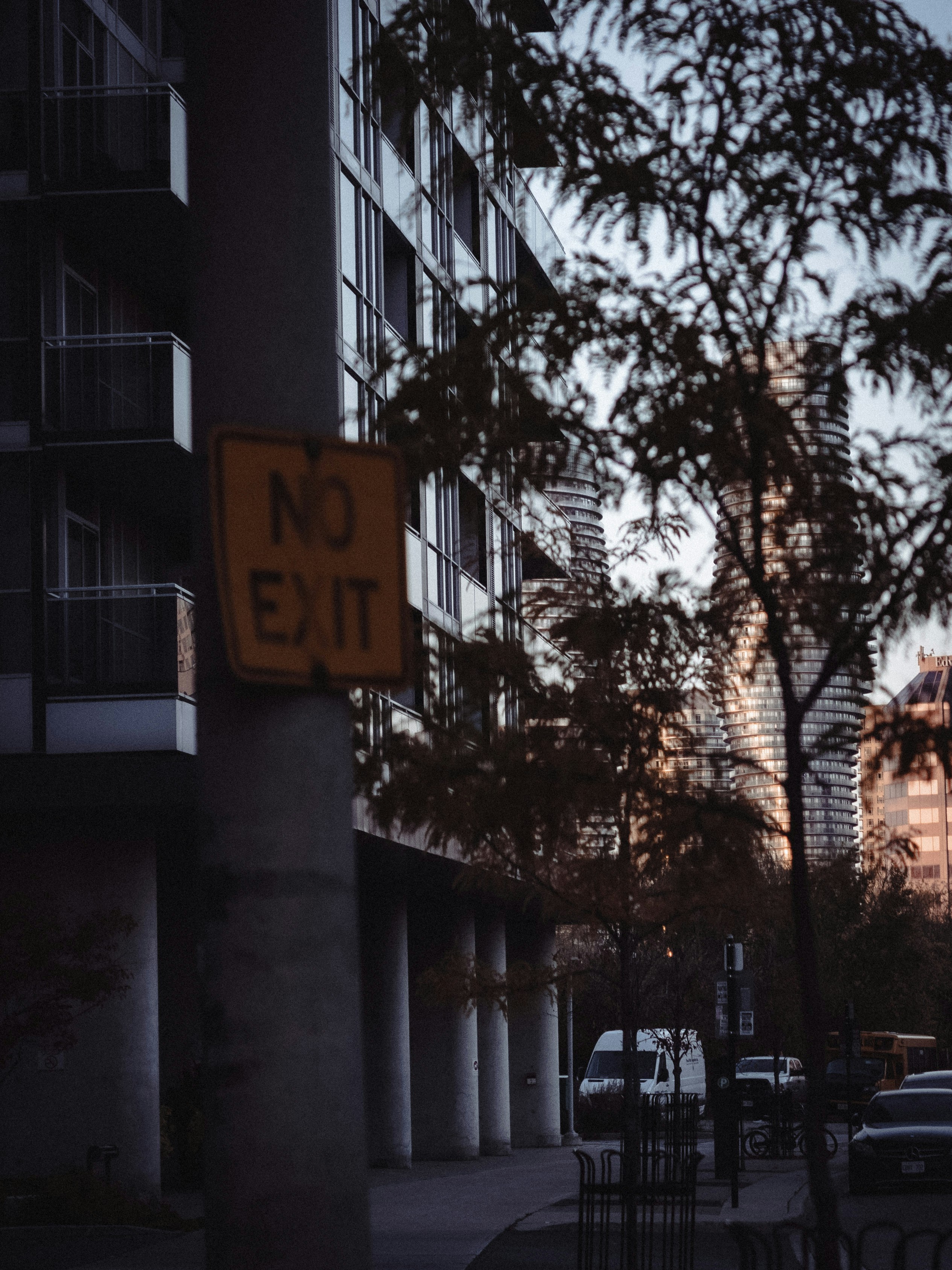 No Exit at Dusk: A Blurred Sign Framed by Urban Silhouettes