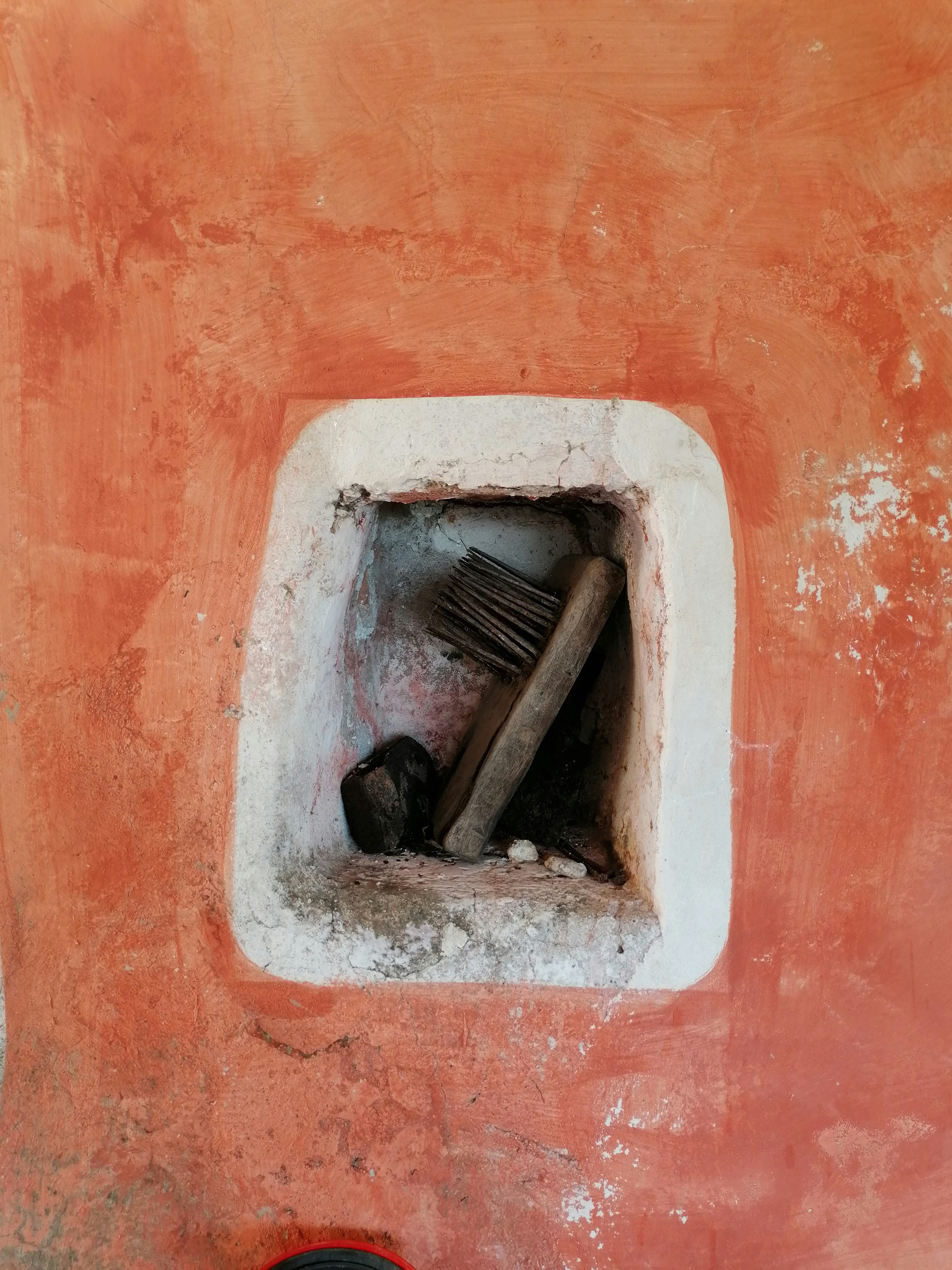 Ember Nook: Charred Debris in a White-Framed Recess on an Orange Wall
