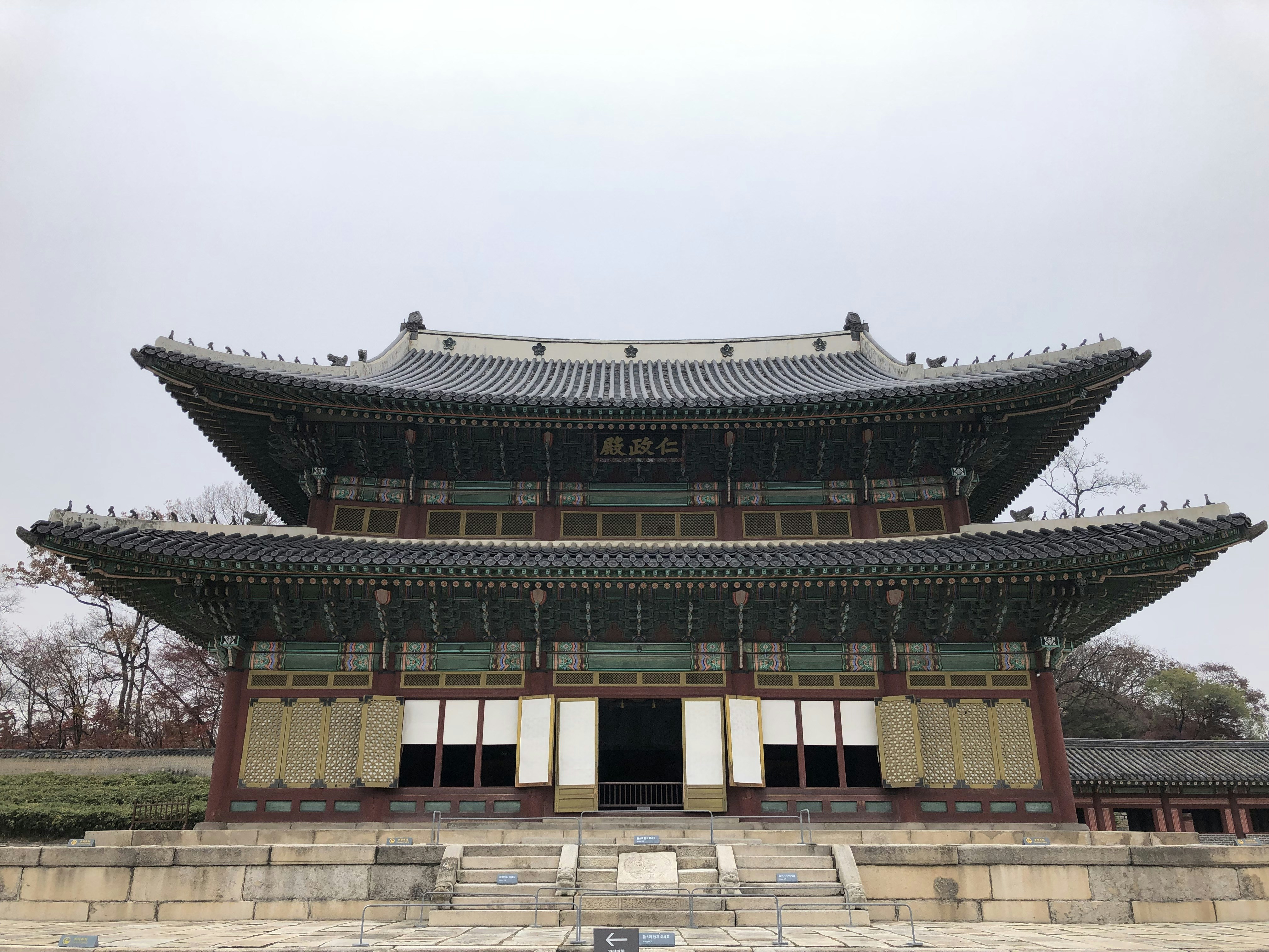 On a four hour layover in Seoul, I took the bus to the Changdeokgung Palace and got the place largely to my self. What a fascinating place of Korean architecture and art. If you have the time take the time to visit here. If doing it on a layover, make sure to purchase bus tickets in both directions. It was a mess trying to get back to the airport. Thank you, to whoever stood up and purchased my bus pass back to the airport. | a building with a large roof