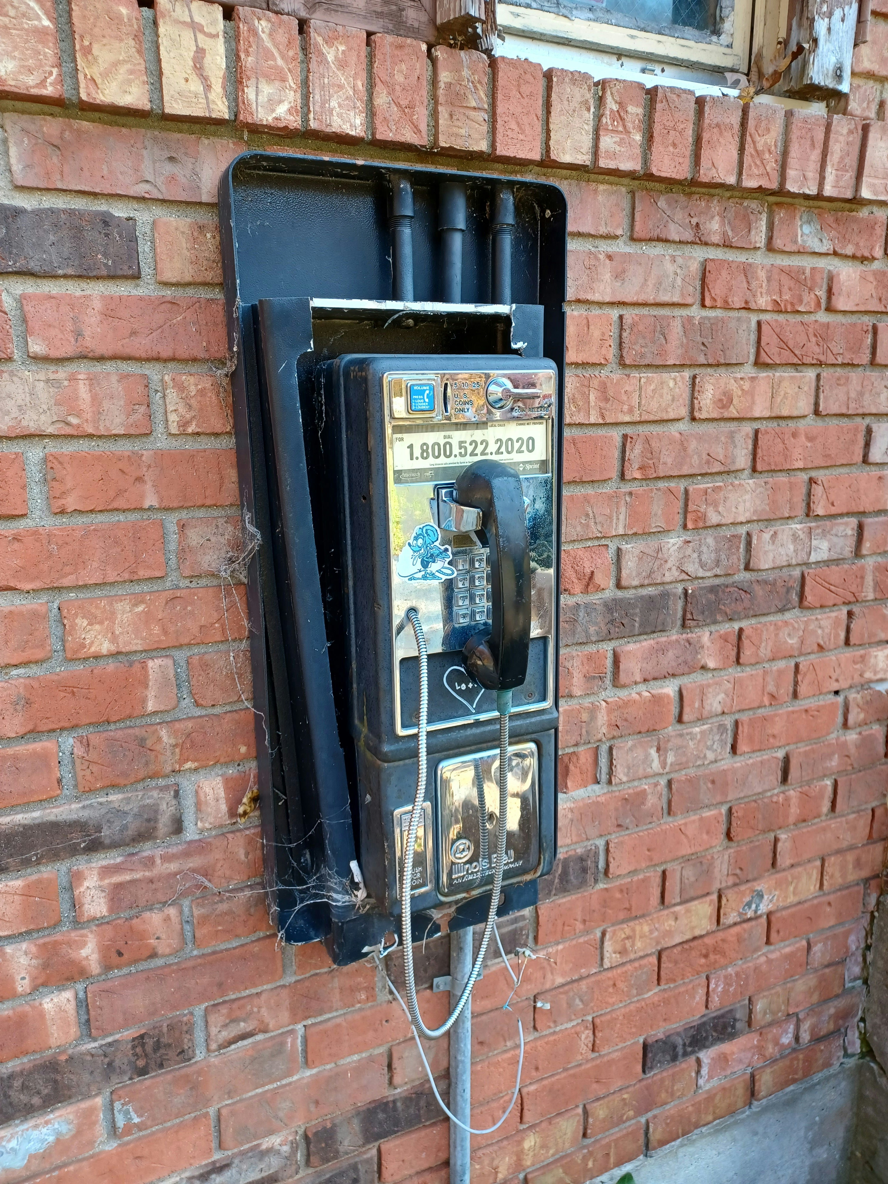 A telephone box on a brick wall photo – Free Phone booth Image on Unsplash