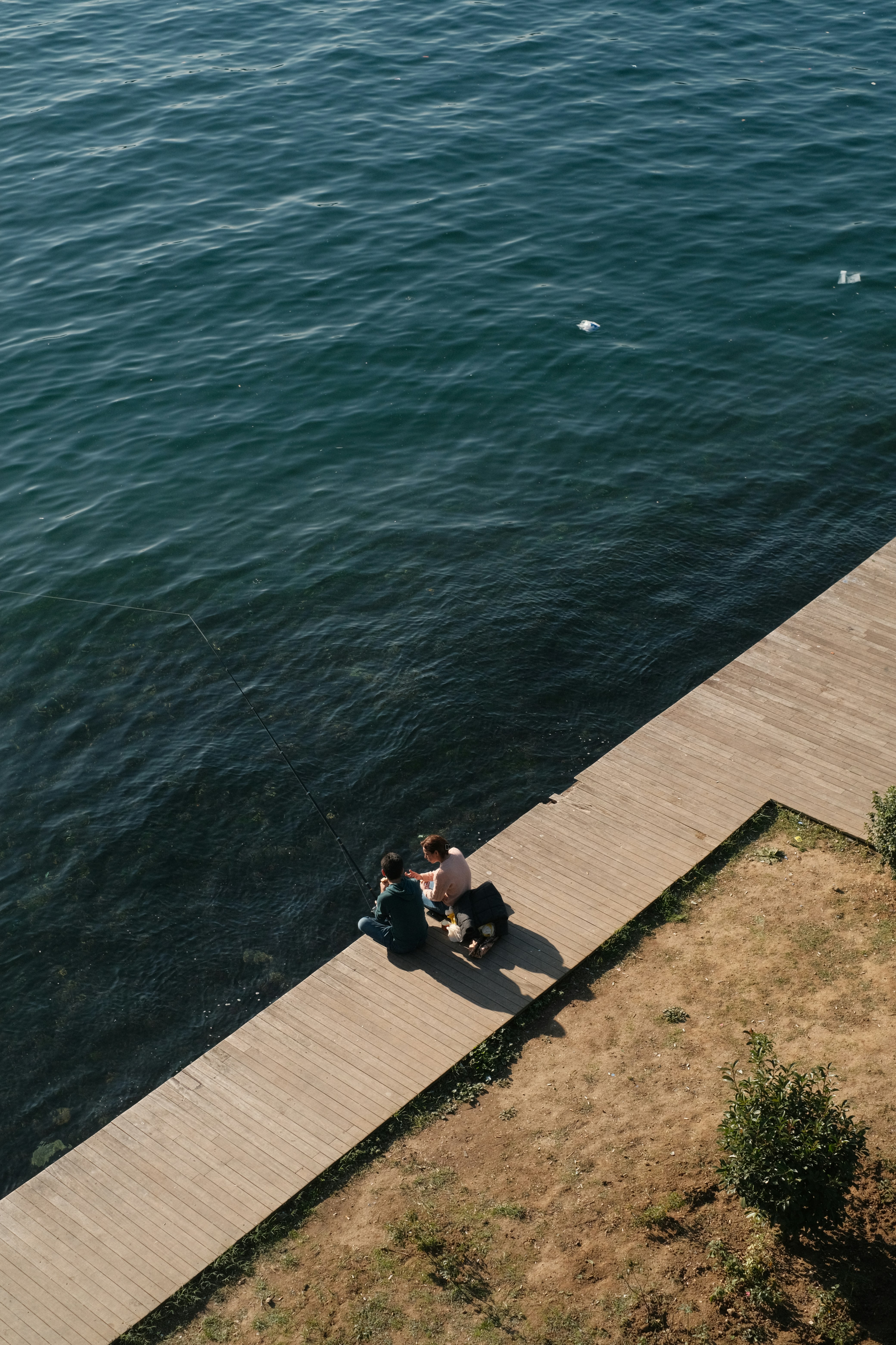 Un groupe de personnes assises sur un quai au bord de l’eau photo ...