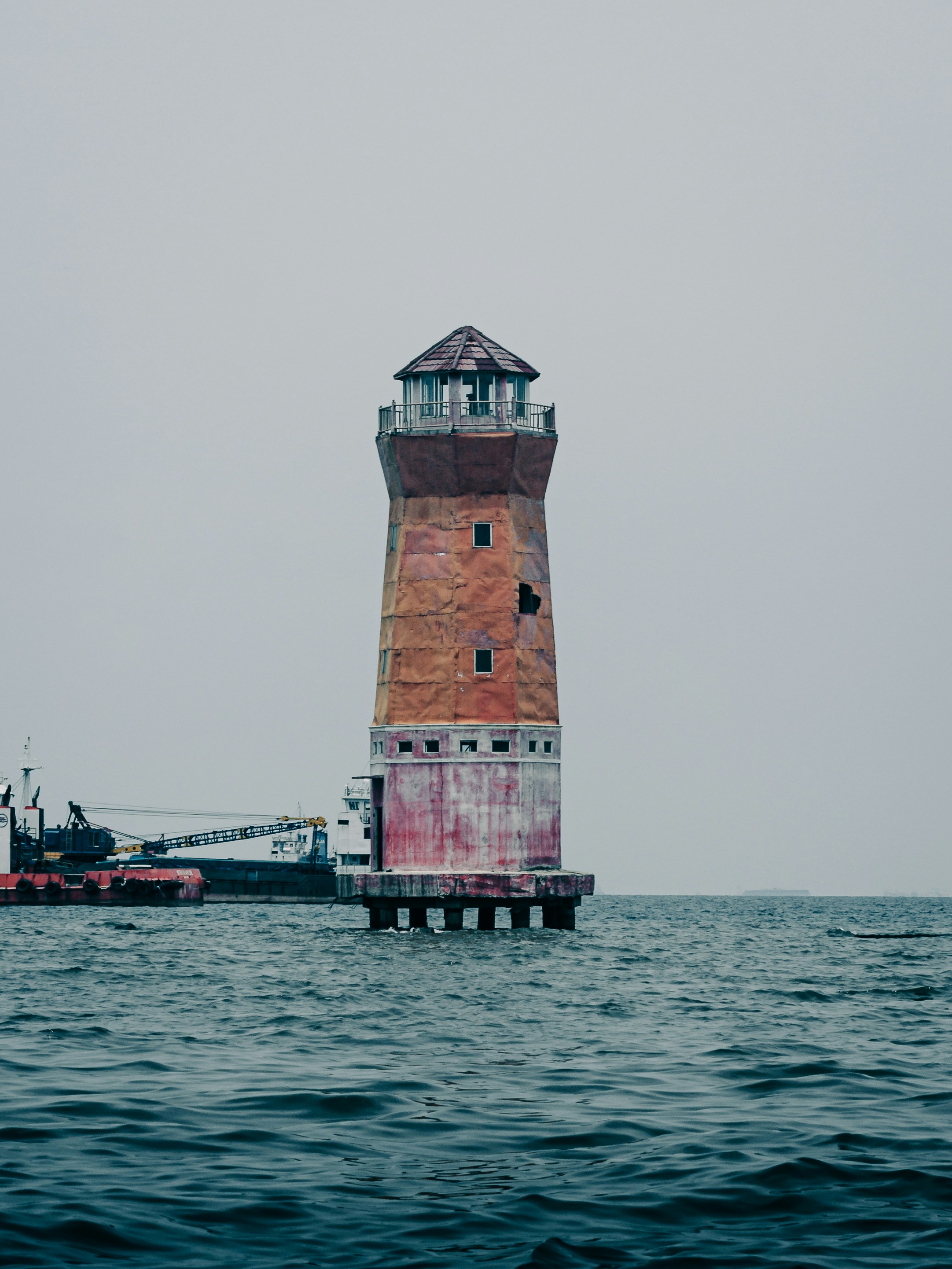 A lighthouse in the middle of the ocean photo – Free Sunda kelapa Image ...