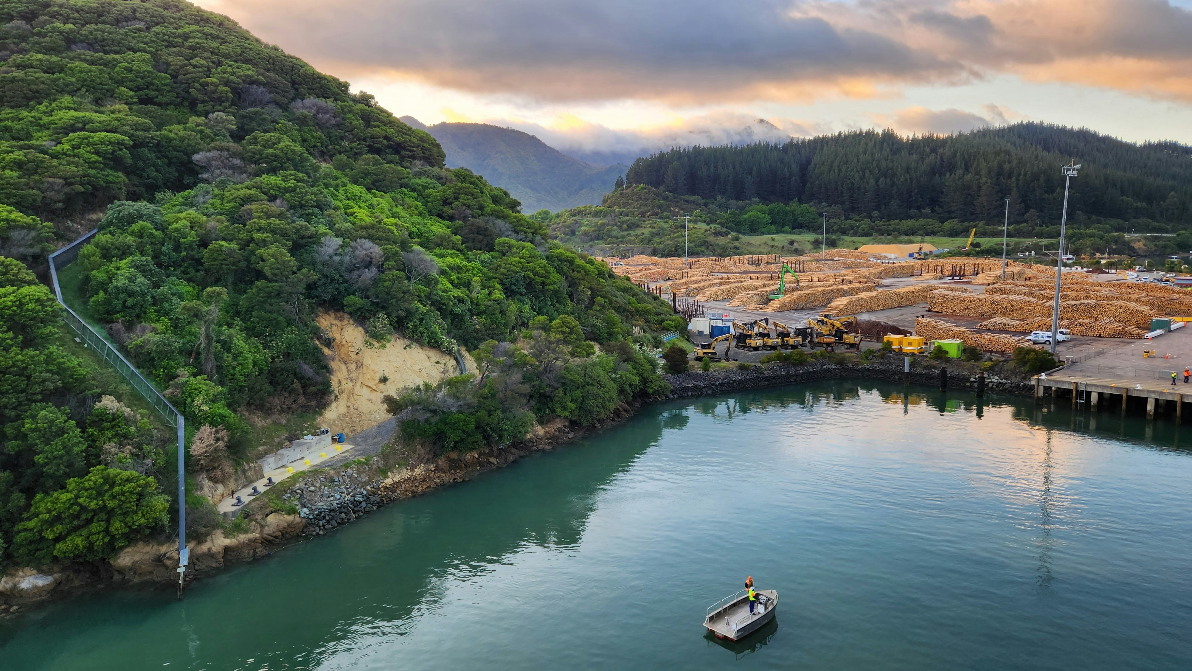 Inlet Afloat: A Lone Boat Traces Calm Turquoise Waters Beneath Verdant Cliffs at Dusk