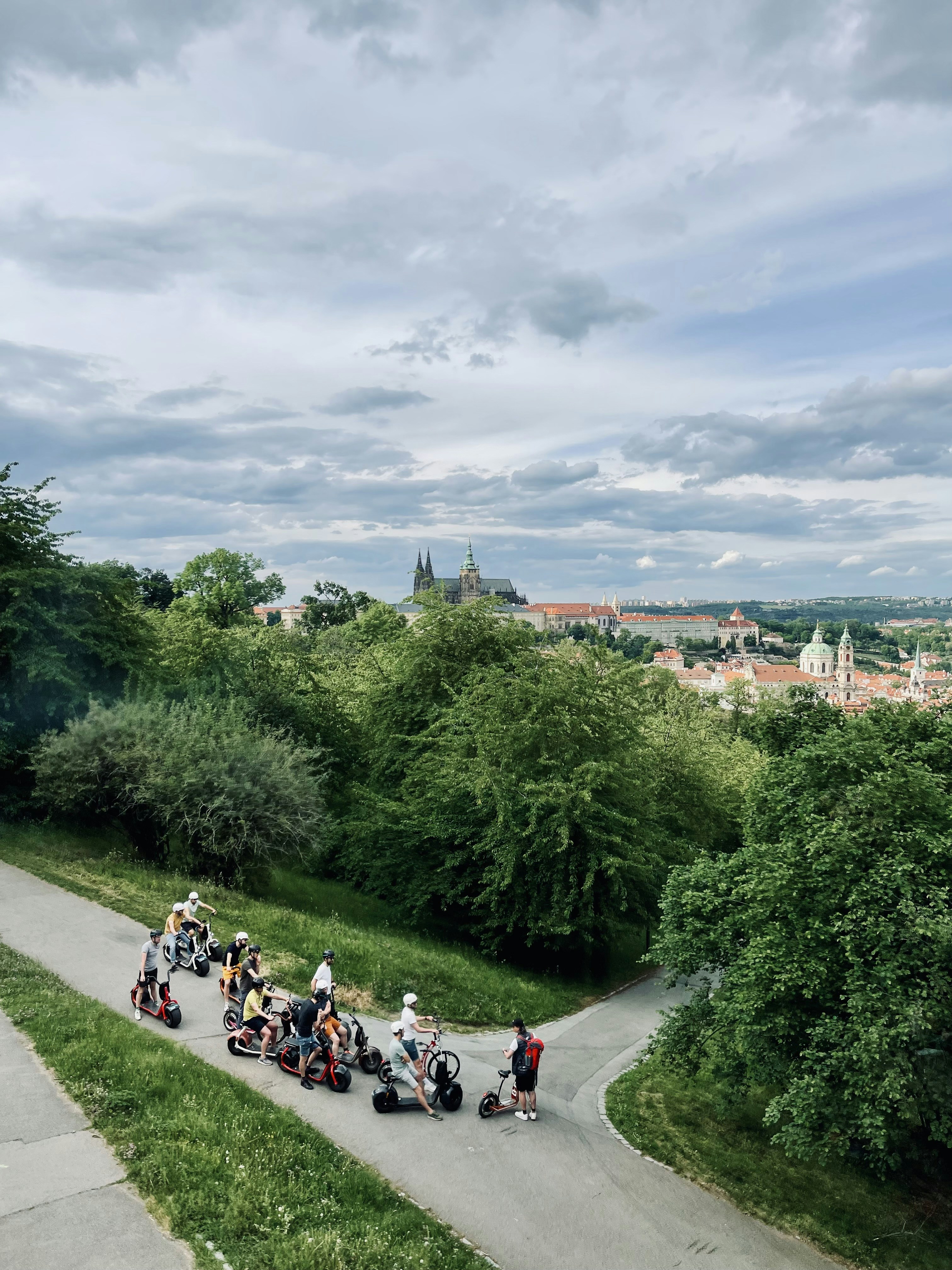 Hilltop Scooter Assembly: Verdant Slopes and a Distant Spired Skyline