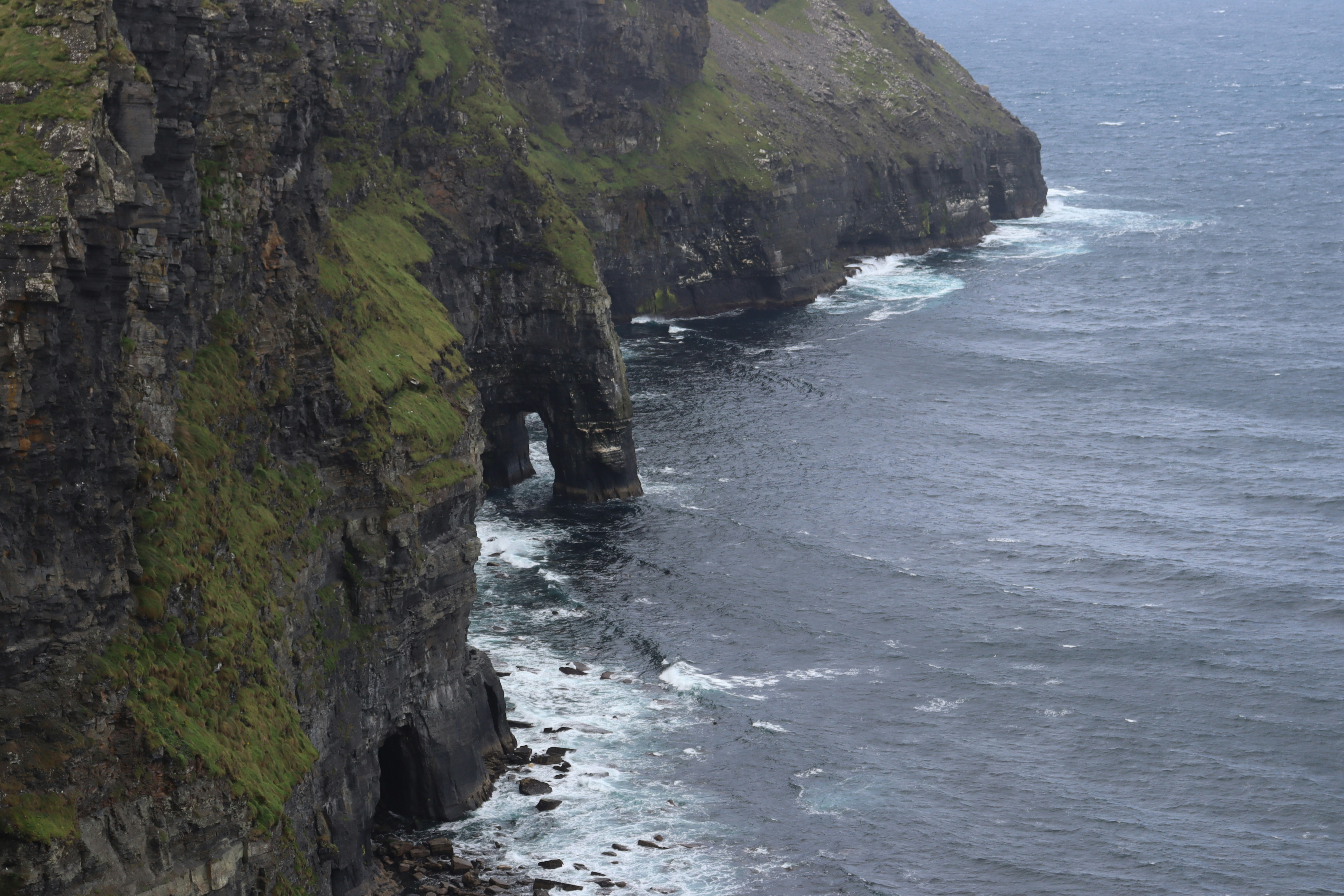 A cliff with a body of water below photo – Free Cliffs of moher Image ...