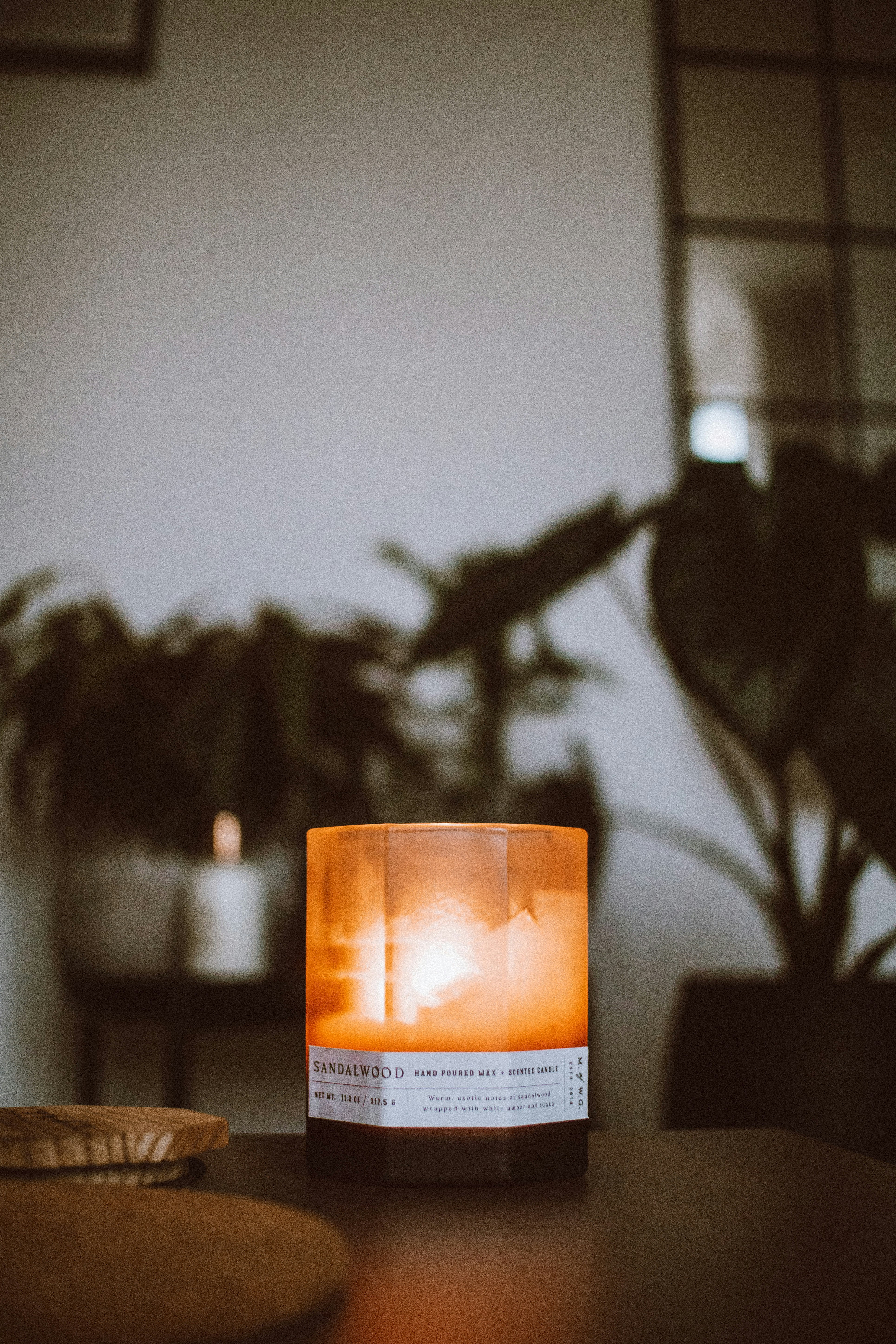 Amber Glow: A Candle's Quiet Center in a Shadowed Living Room