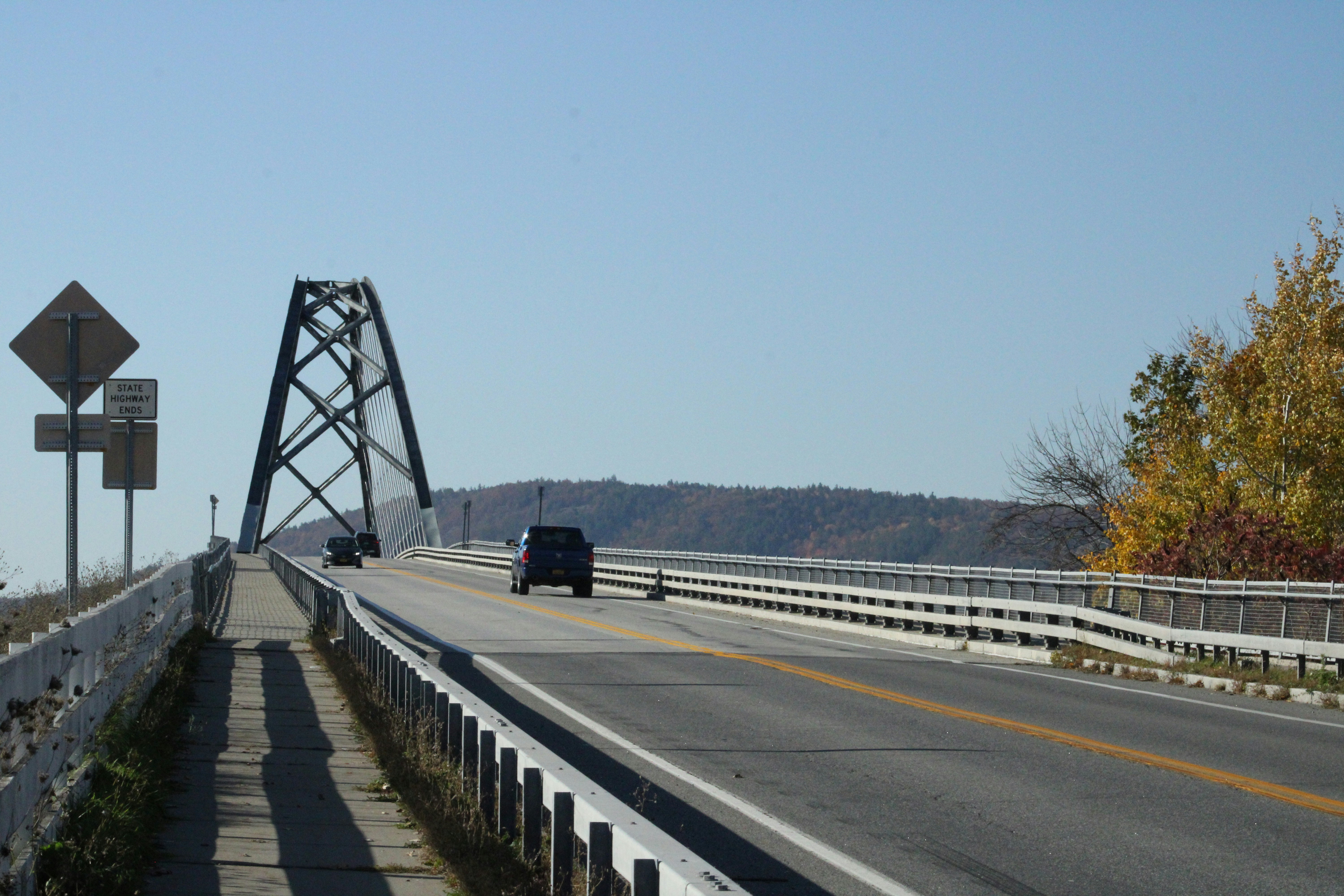Steel-Arch Crossing: Vehicles Pace the Quiet Bridge Toward the Horizon