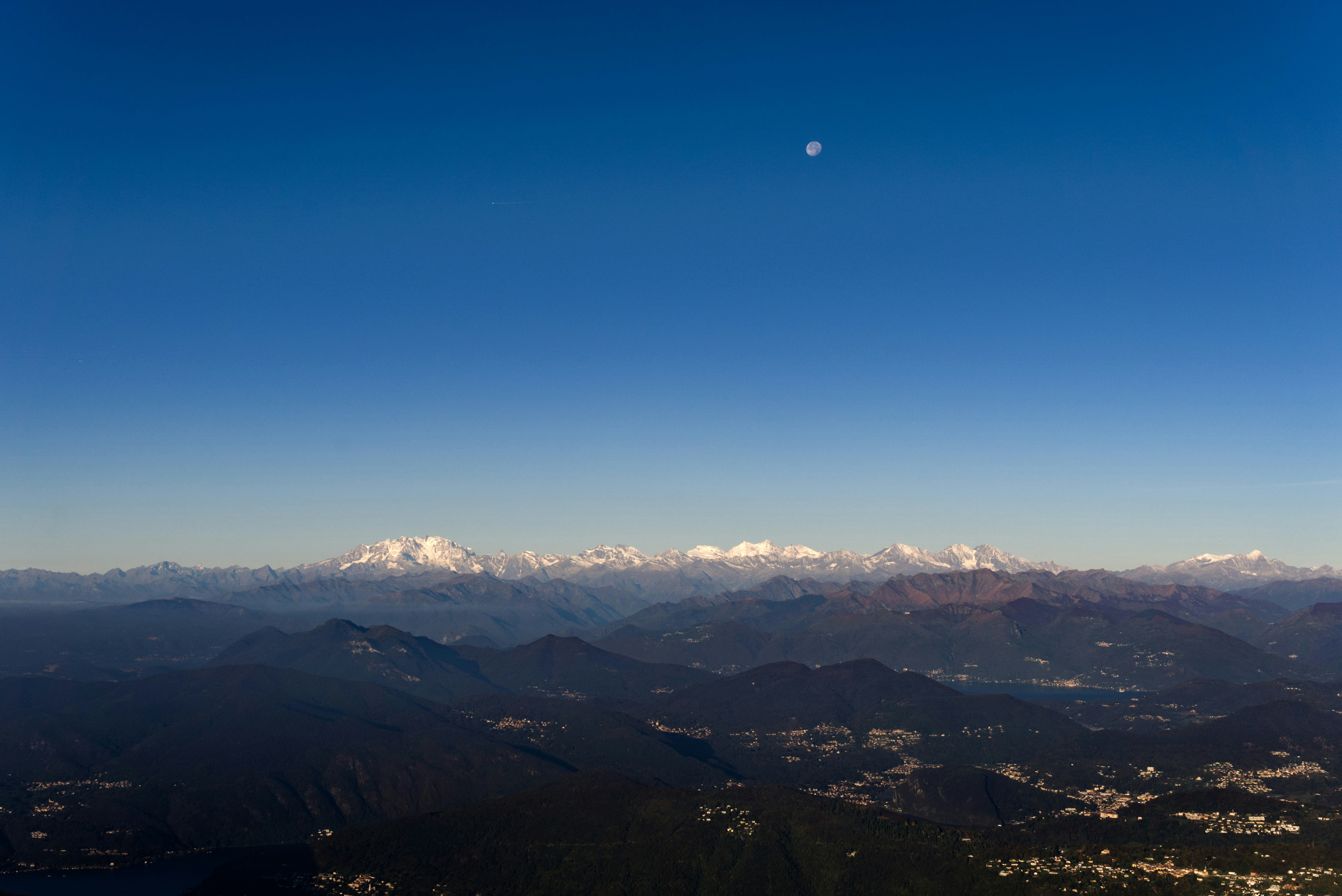 Moon over the snow-dusted horizon: a quiet alpine panorama