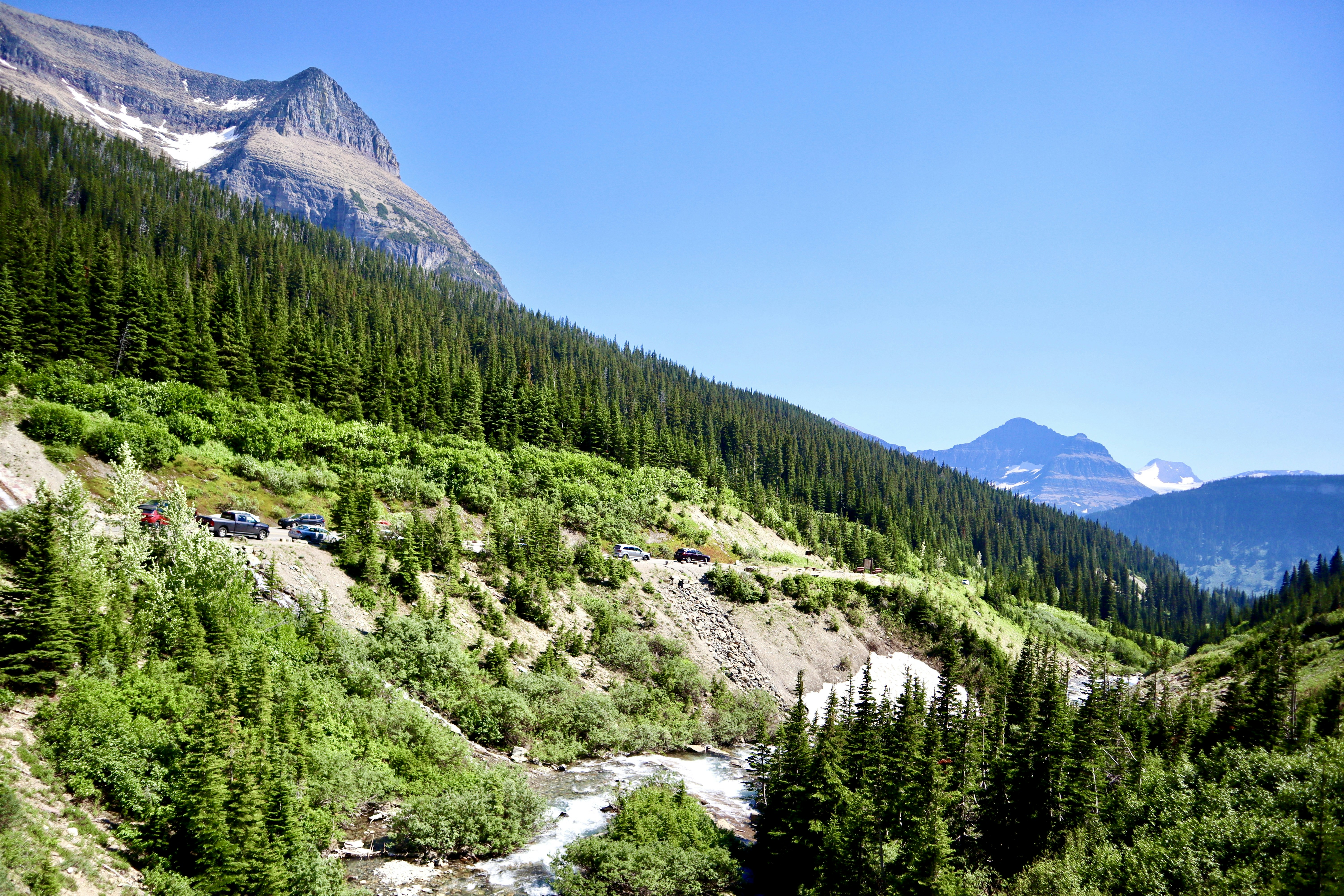 Alpine Byway: Conifer Ridge, River Bend, and a Scatter of Cars