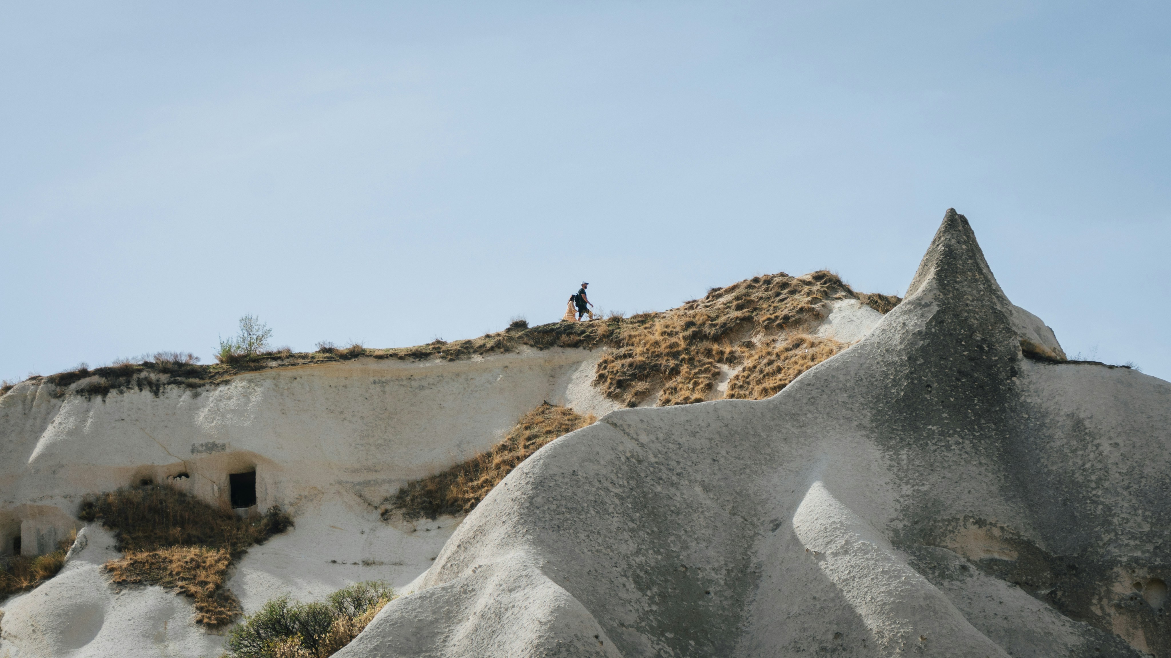 Lone Hiker on a Chalk Ridge Beneath a Wide Blue Sky