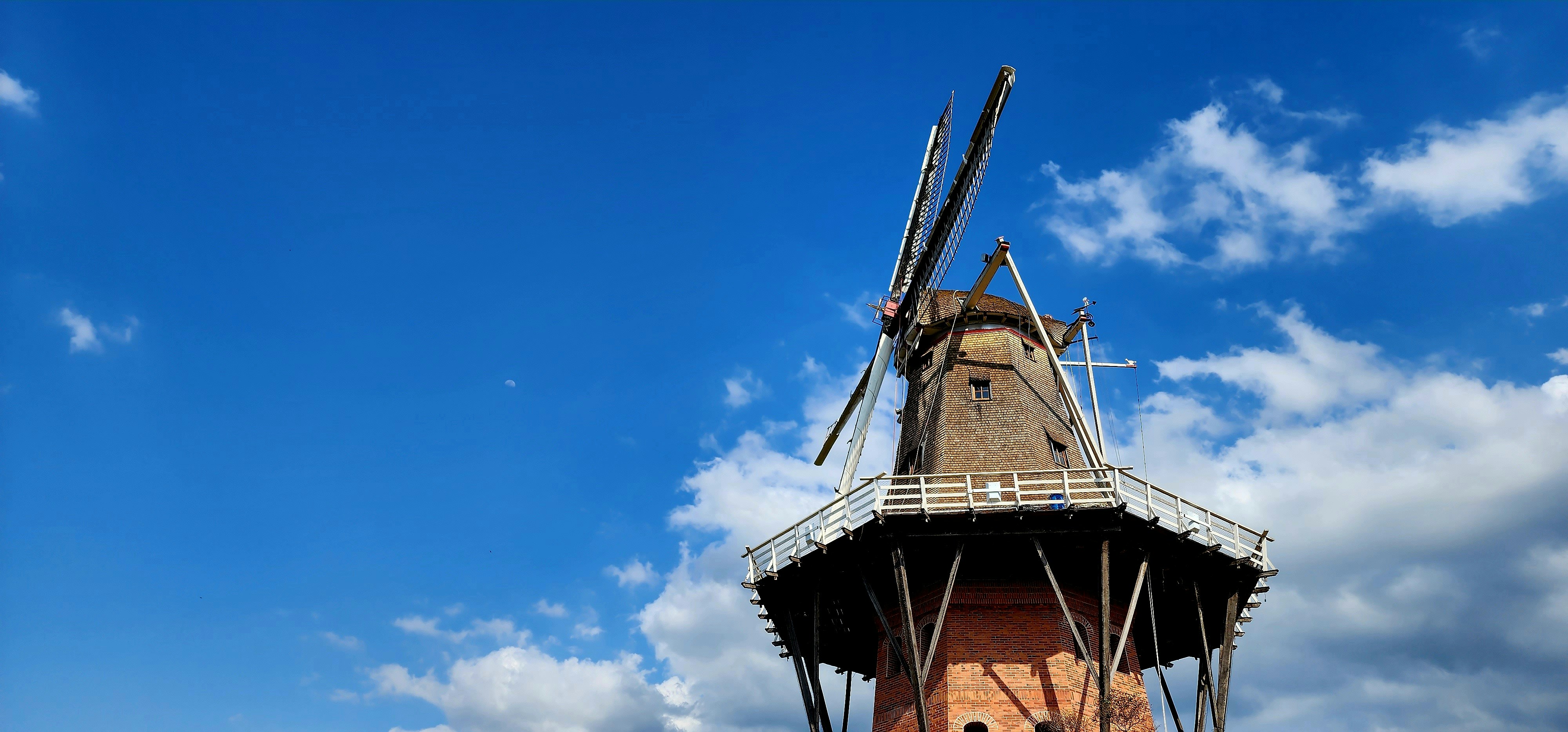 Windmill Tower: Timber Blades Against a Crisp Blue Sky